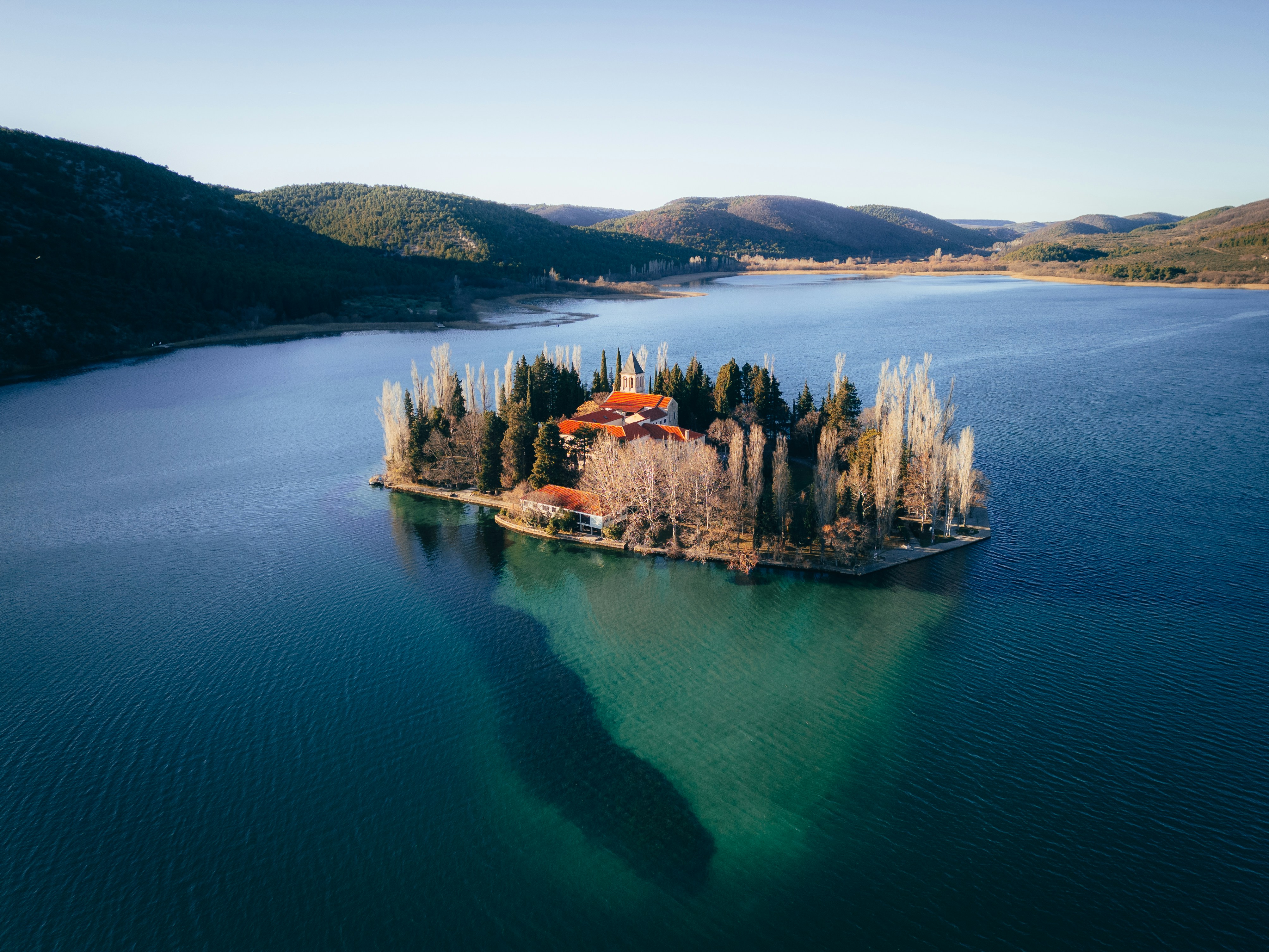 Island with buildings and trees in croatian lake