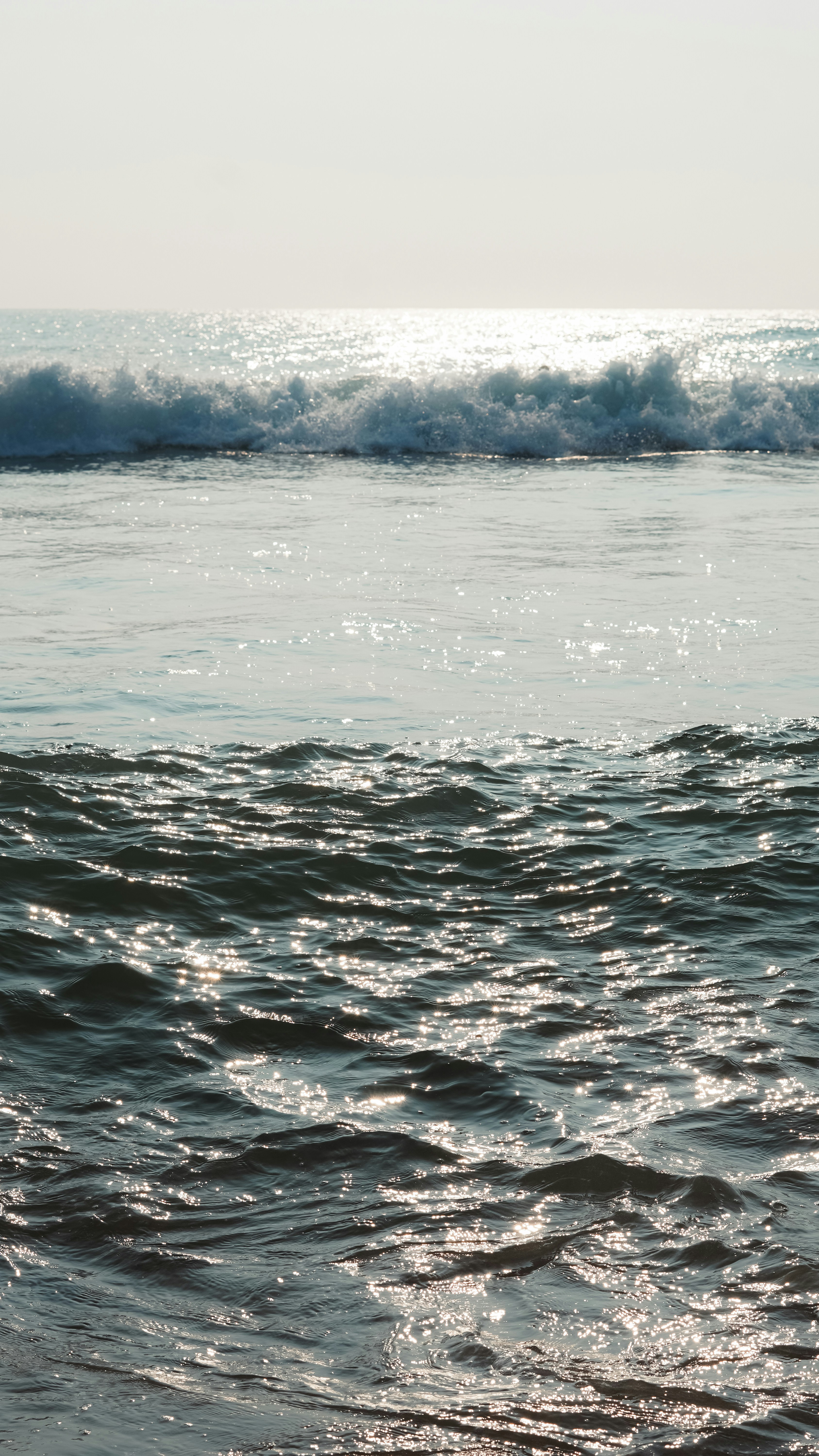 Glassy Horizon: Sunlit Wave Crest over a Quiet Sea