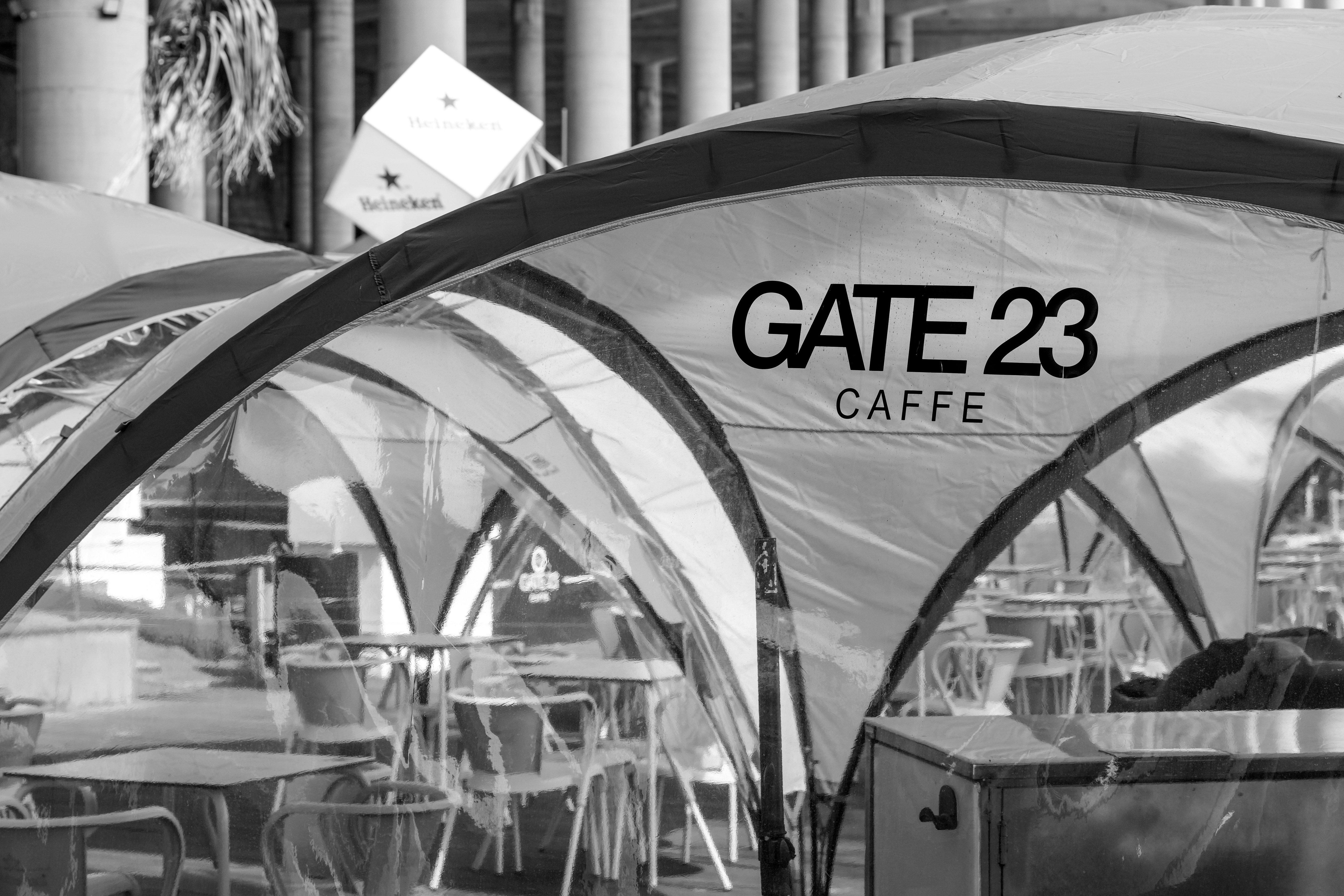 Outdoor cafe tents with a prominent "gate 23 caffe" sign.