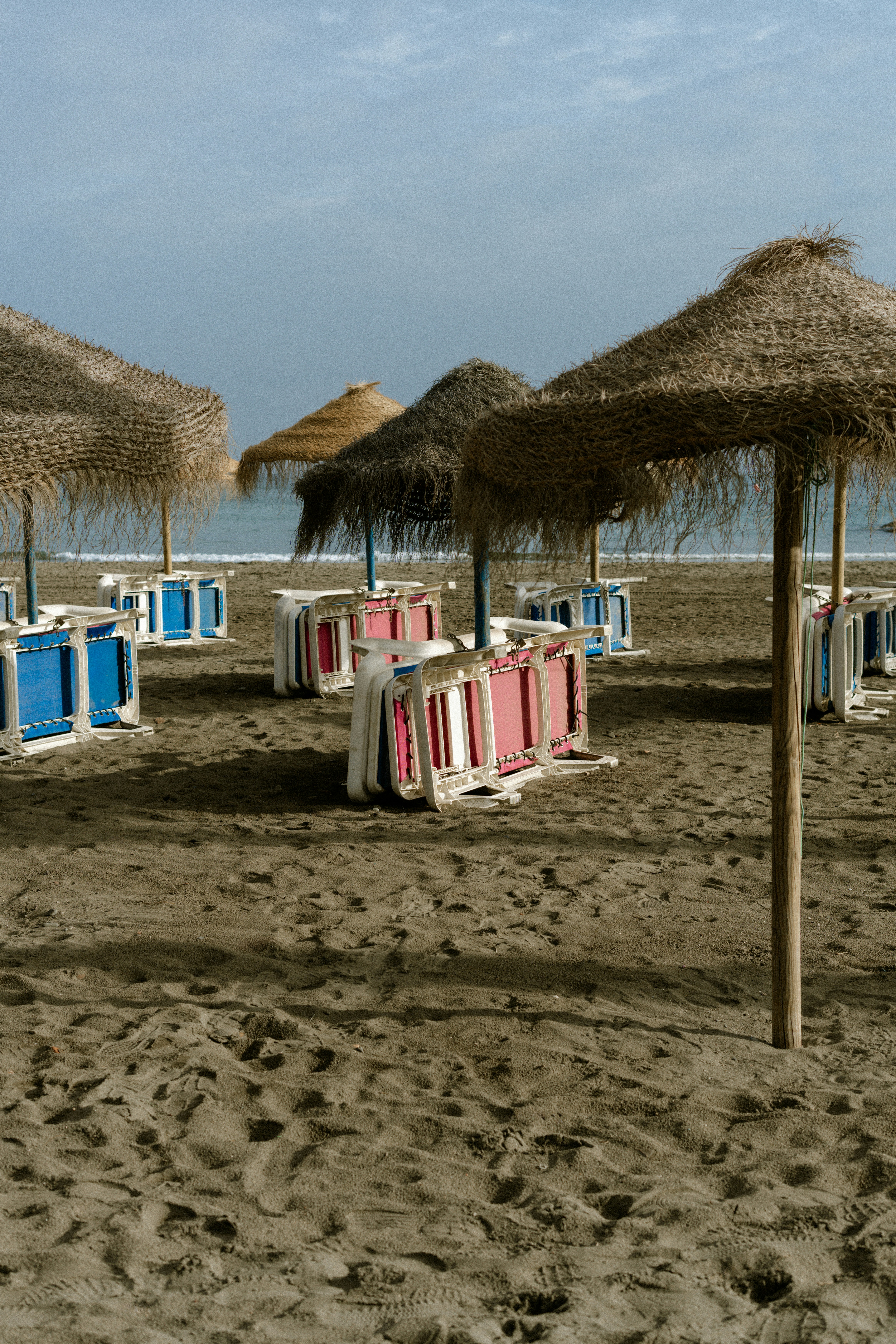 Beachside Loungers Under Thatched Awnings on a Calm Shore