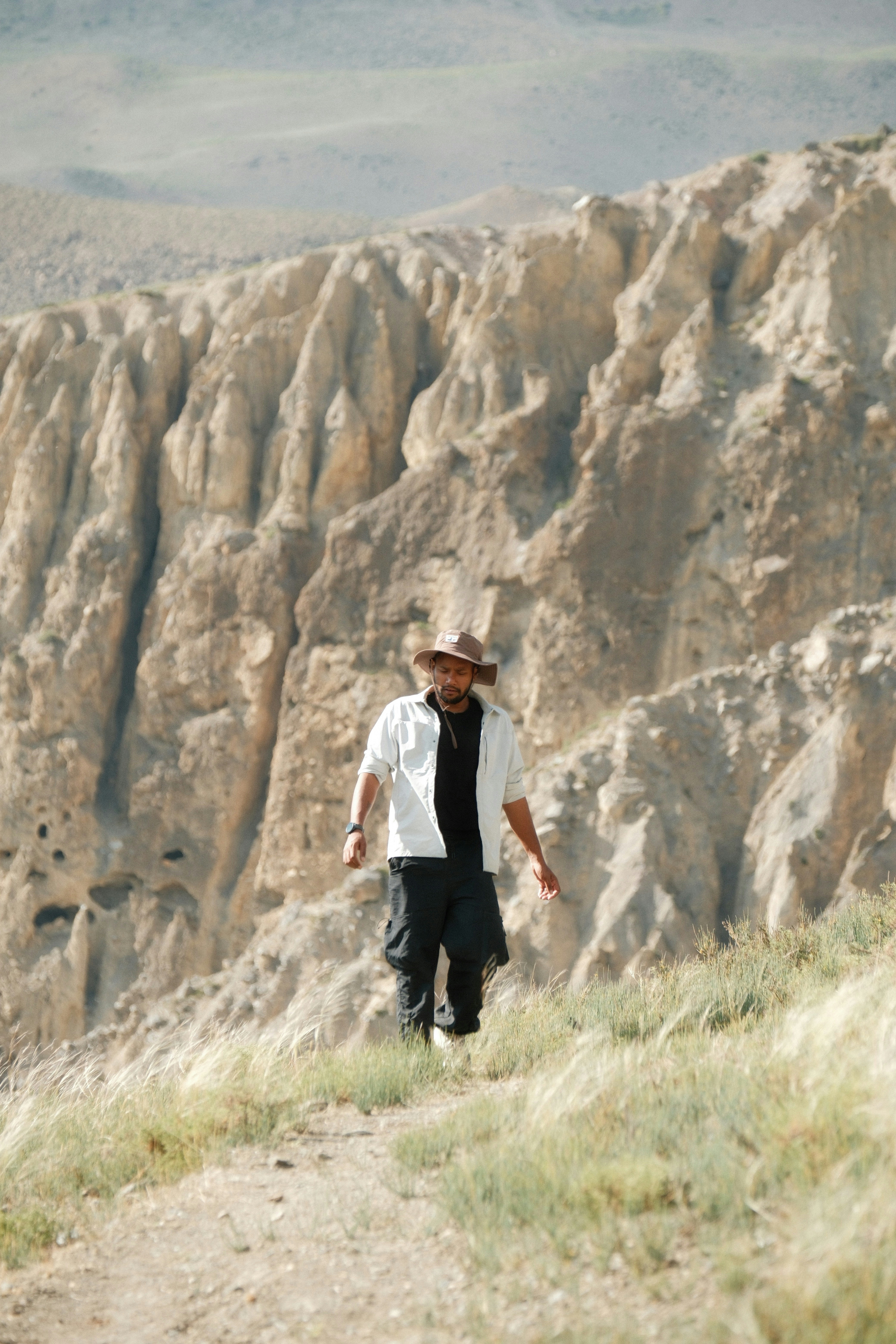 Path to the Cliffs: A Lone Traveler Across Sunlit Dunes