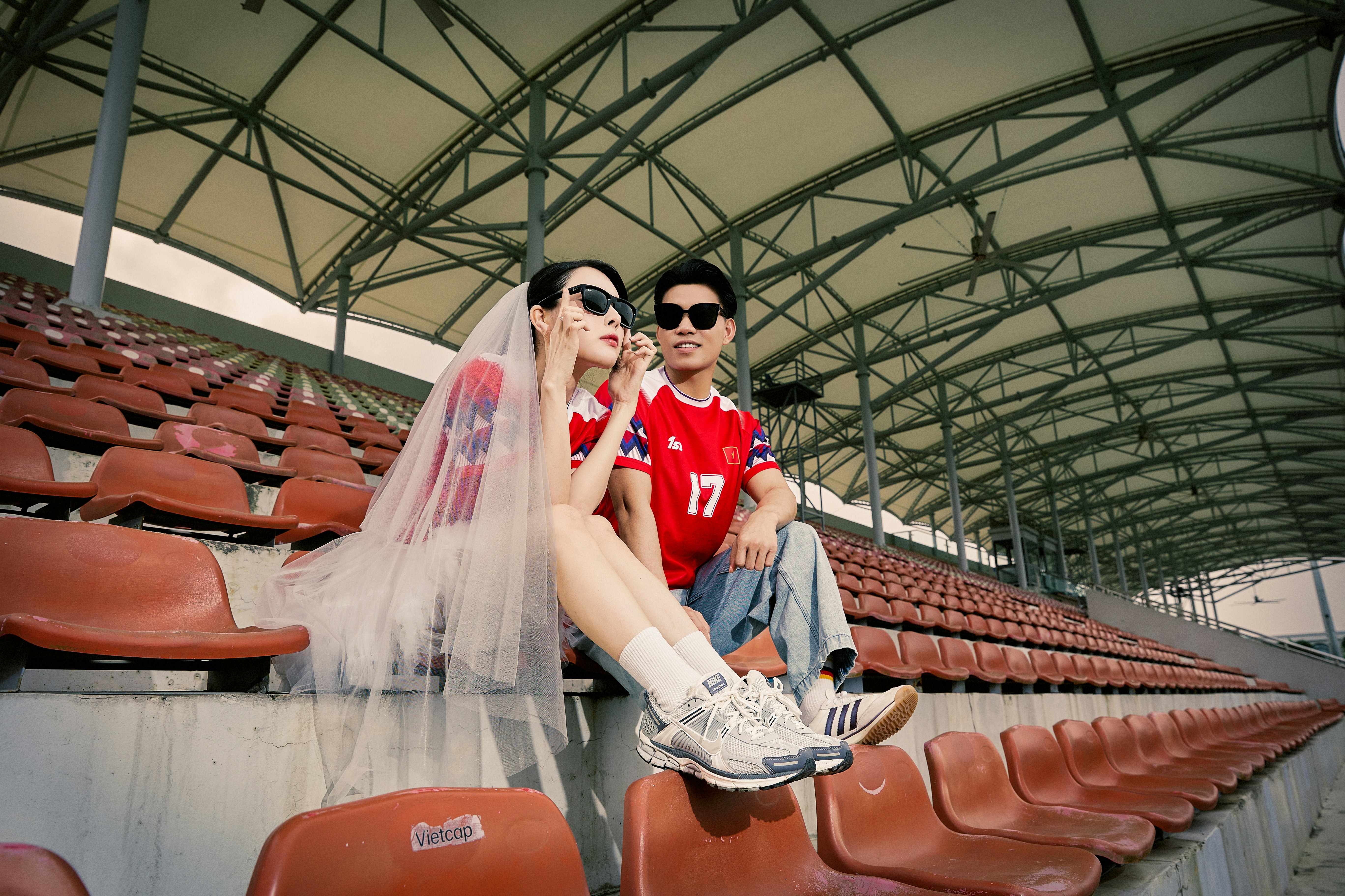 Fans in Red Jerseys Share a Moment Under Stadium Canopy