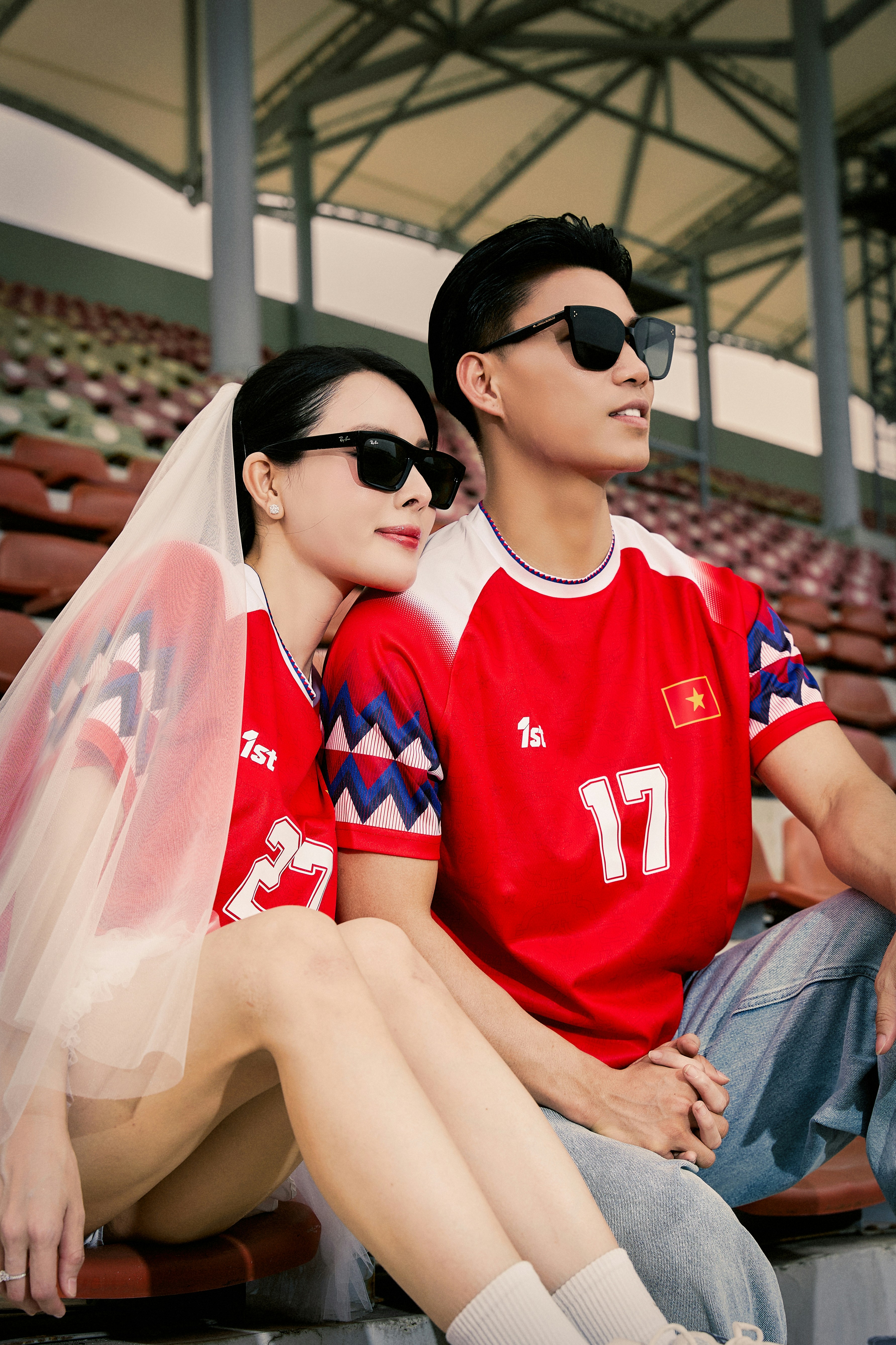 Couple in Matching Red Jerseys Shares a Quiet Moment Under Stadium Banners