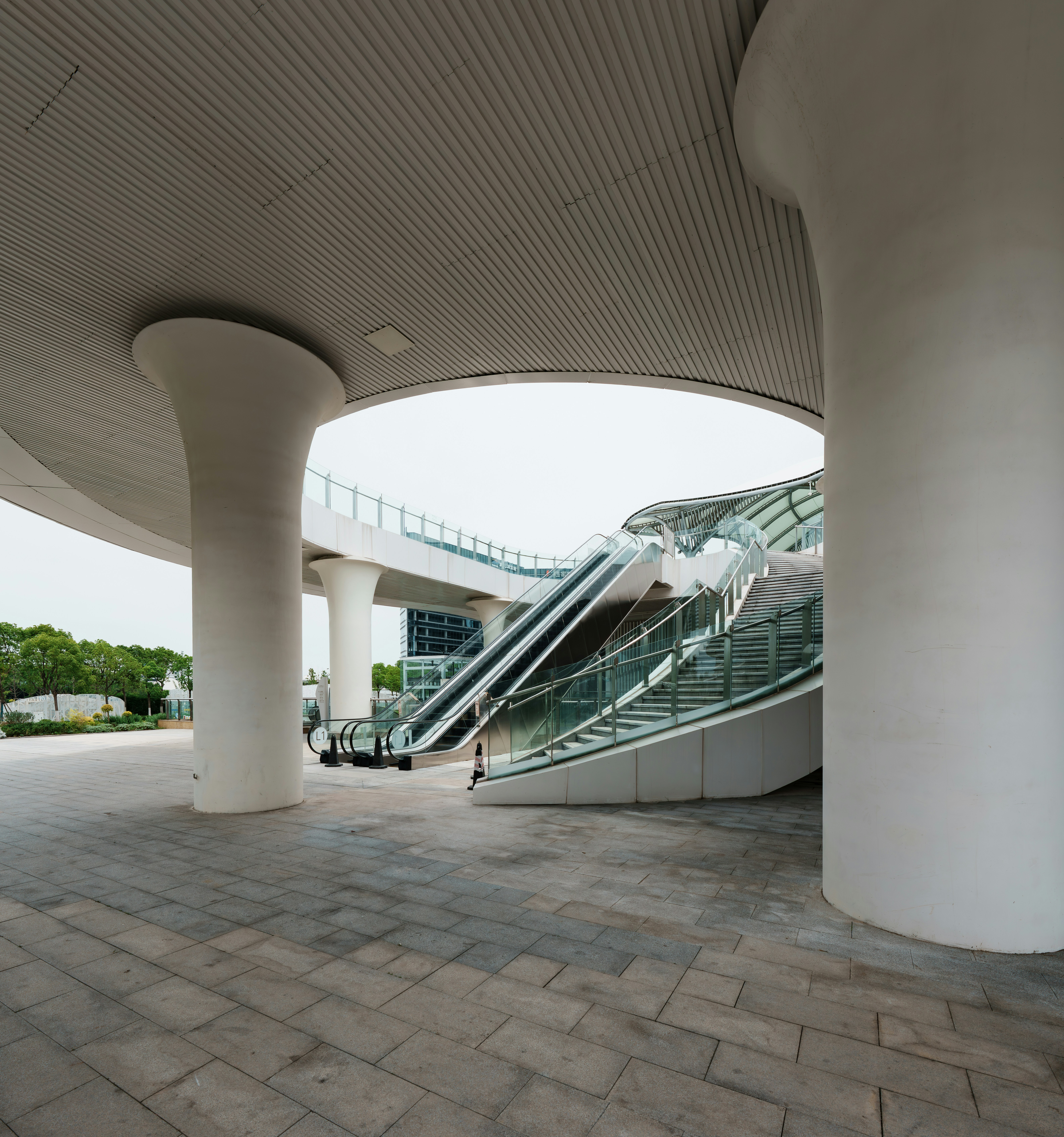 Curved Canopy and Staircase: Modern Architecture Framed by Concrete Columns