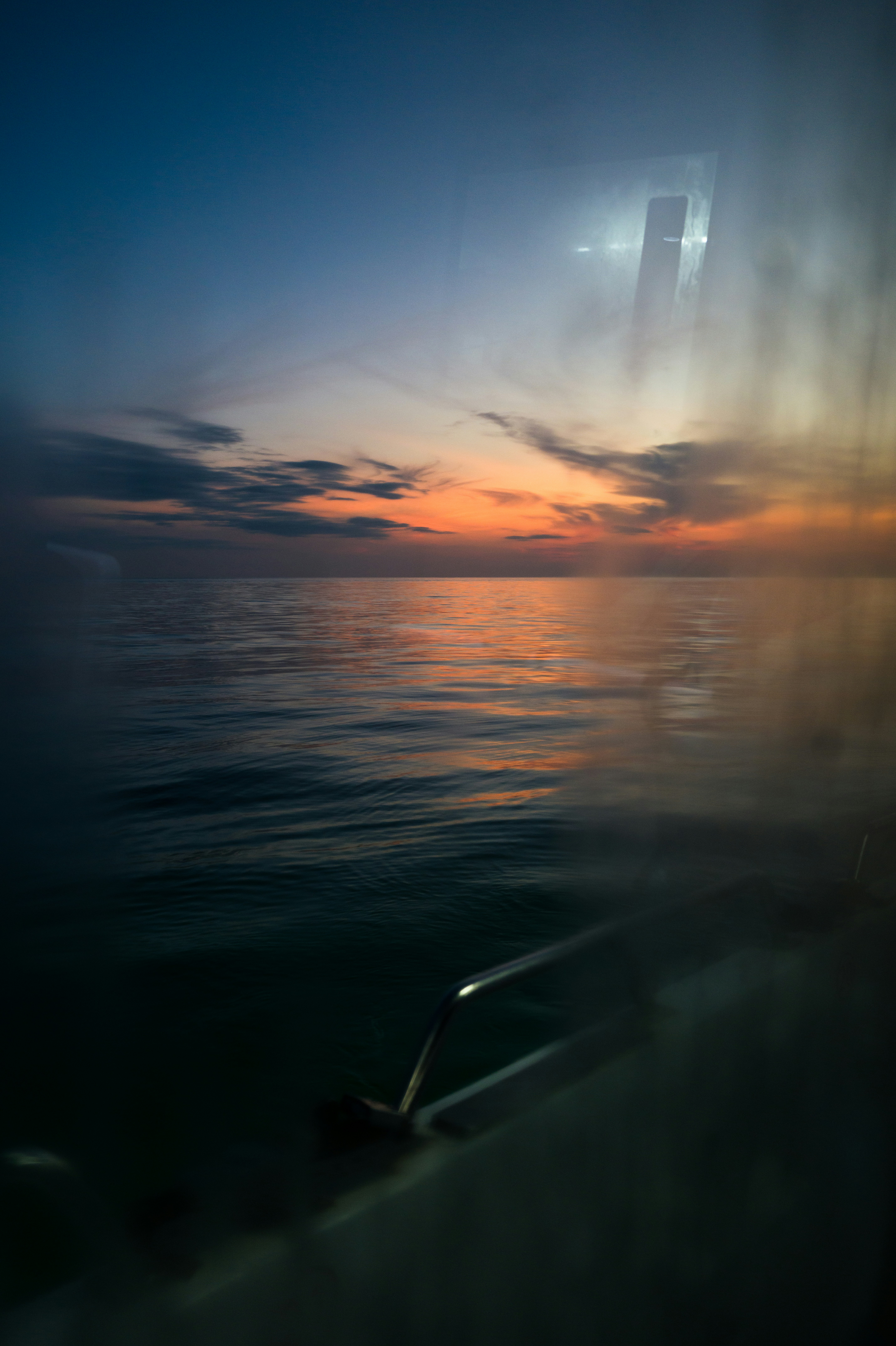 Sunset Over Calm Waters Reflected Through a Veiled Window