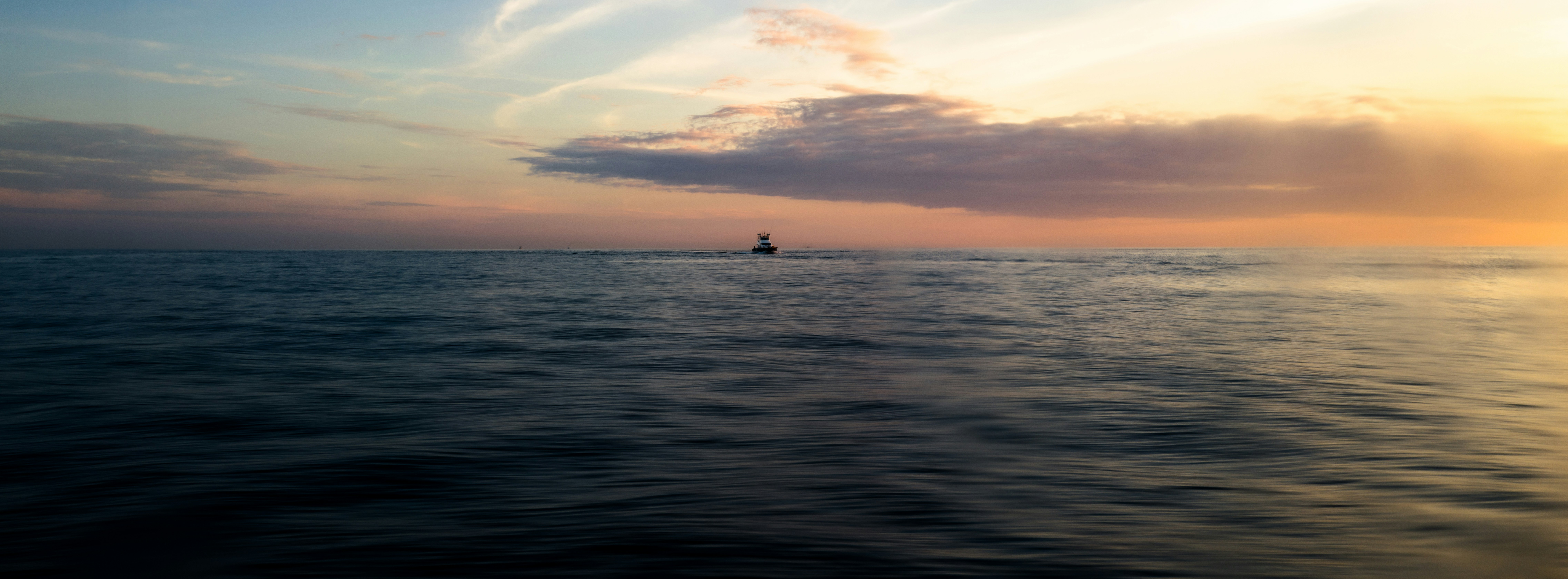 Distant Vessel at Sunset: A Quiet Ocean Horizon