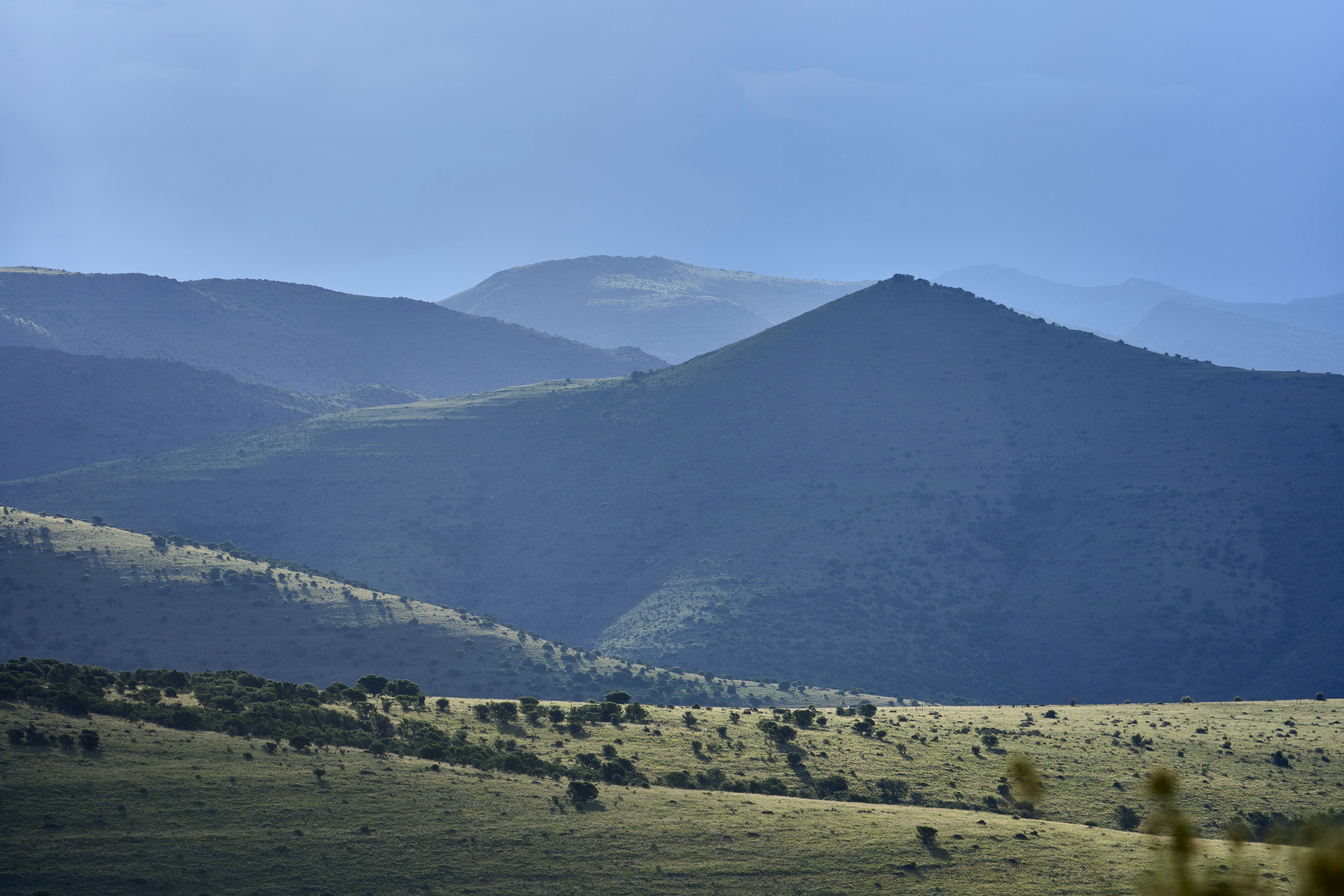 Horizon Layers: Quiet Hills Rolling Under a Soft Blue Sky