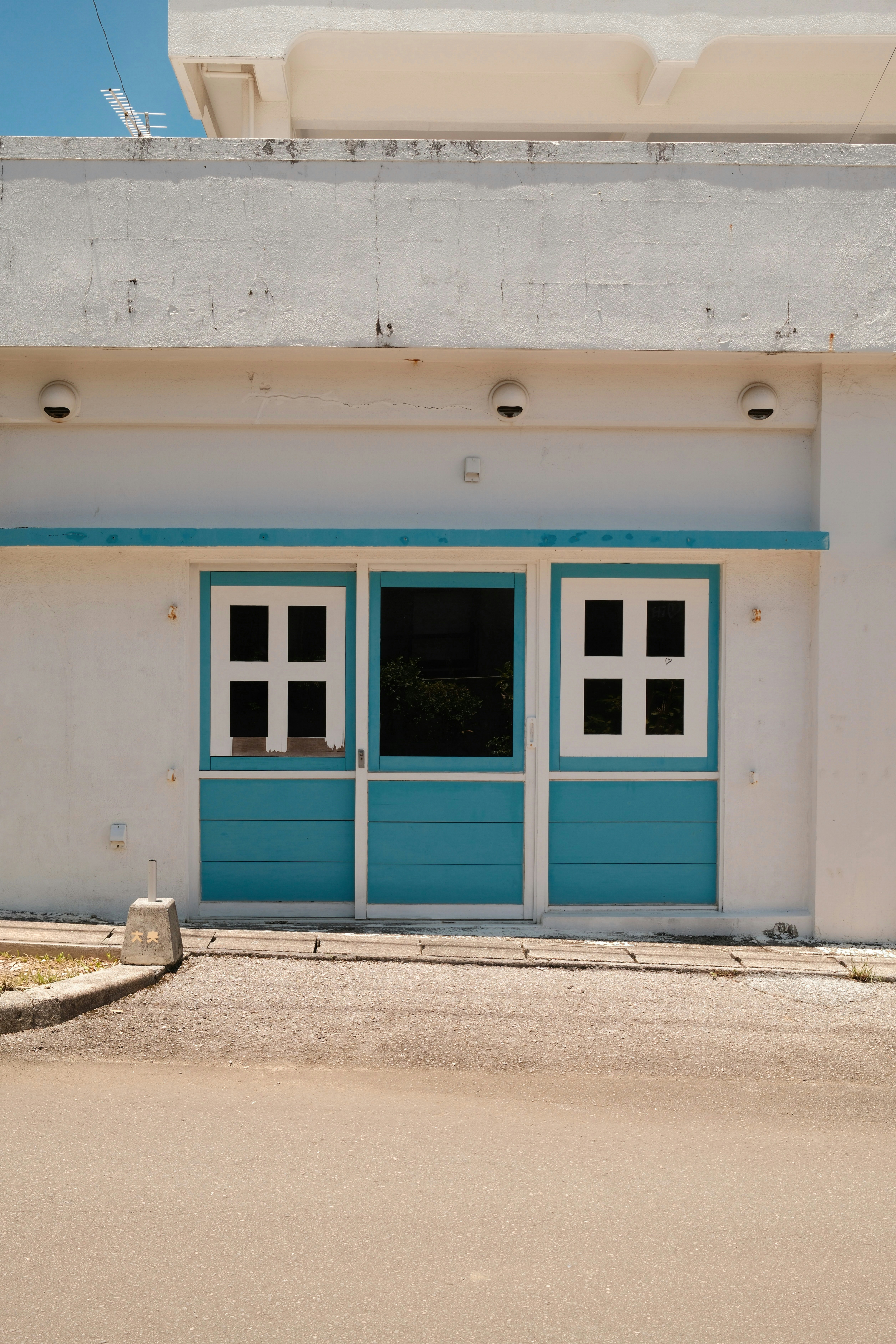 Coastal Blue Storefront: Symmetry and Sunlit Doors