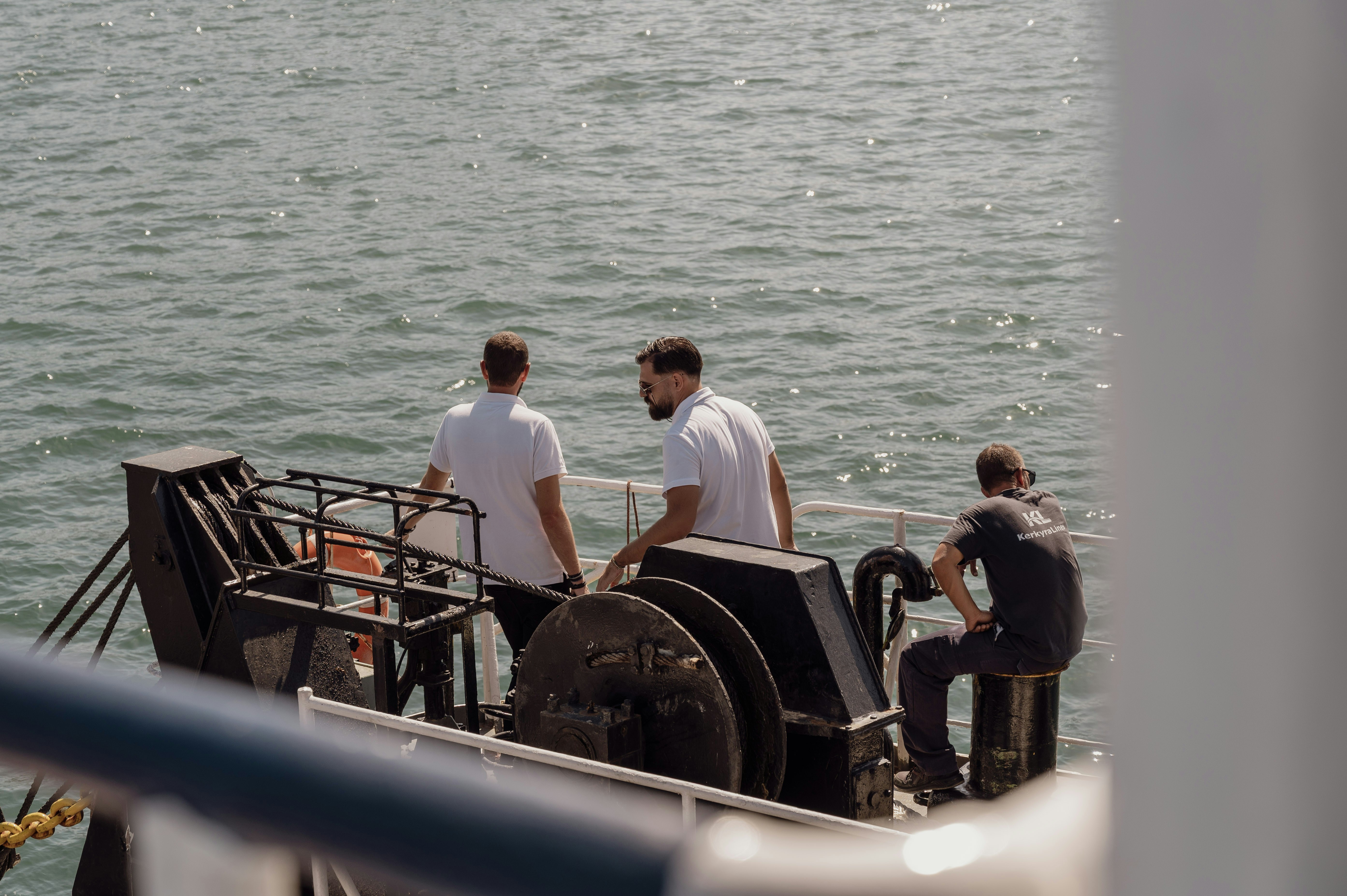 Crew on the Sunlit Pier: A Quiet Moment with Machinery by the Water