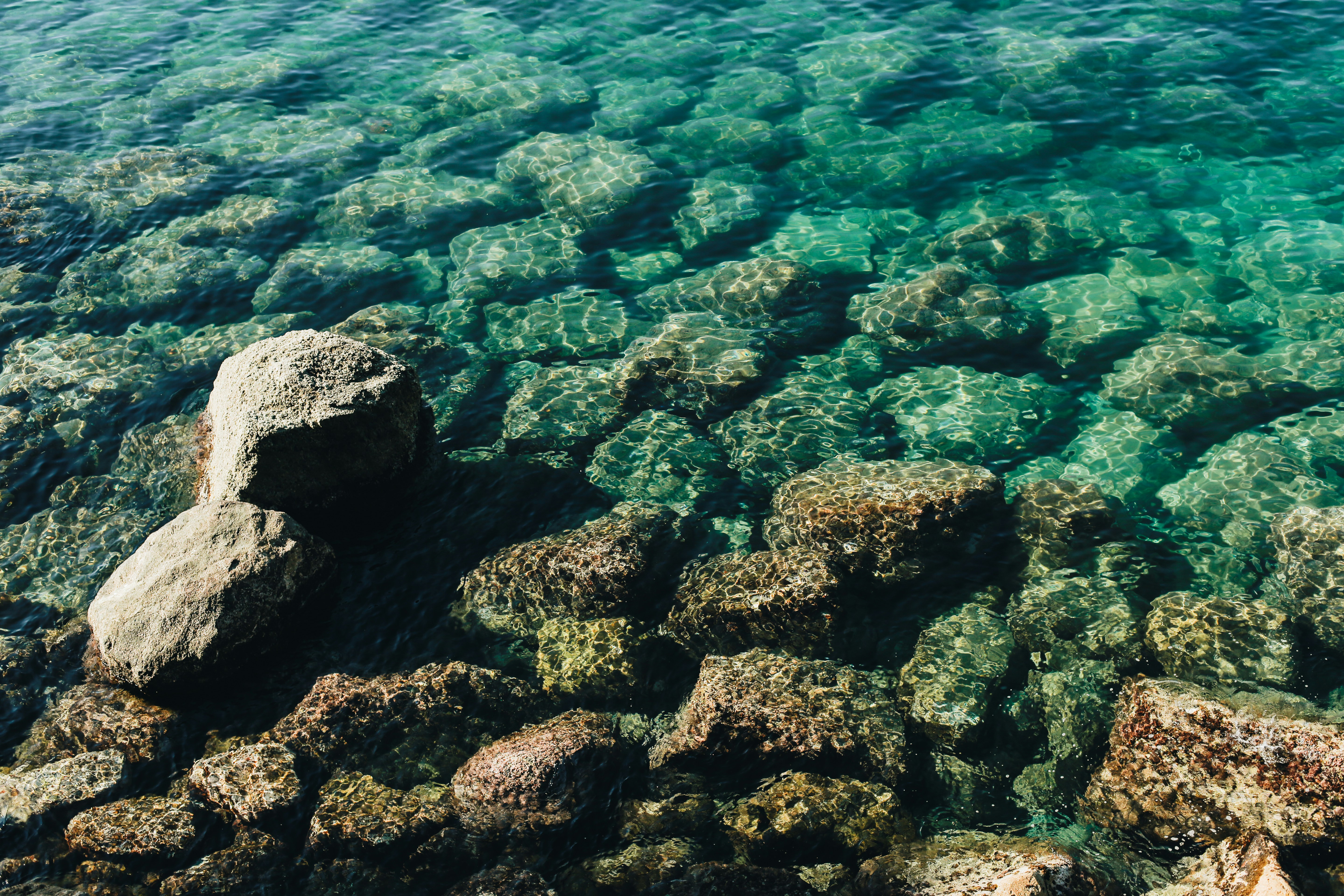Clear turquoise depths: sunlit stones beneath transparent water
