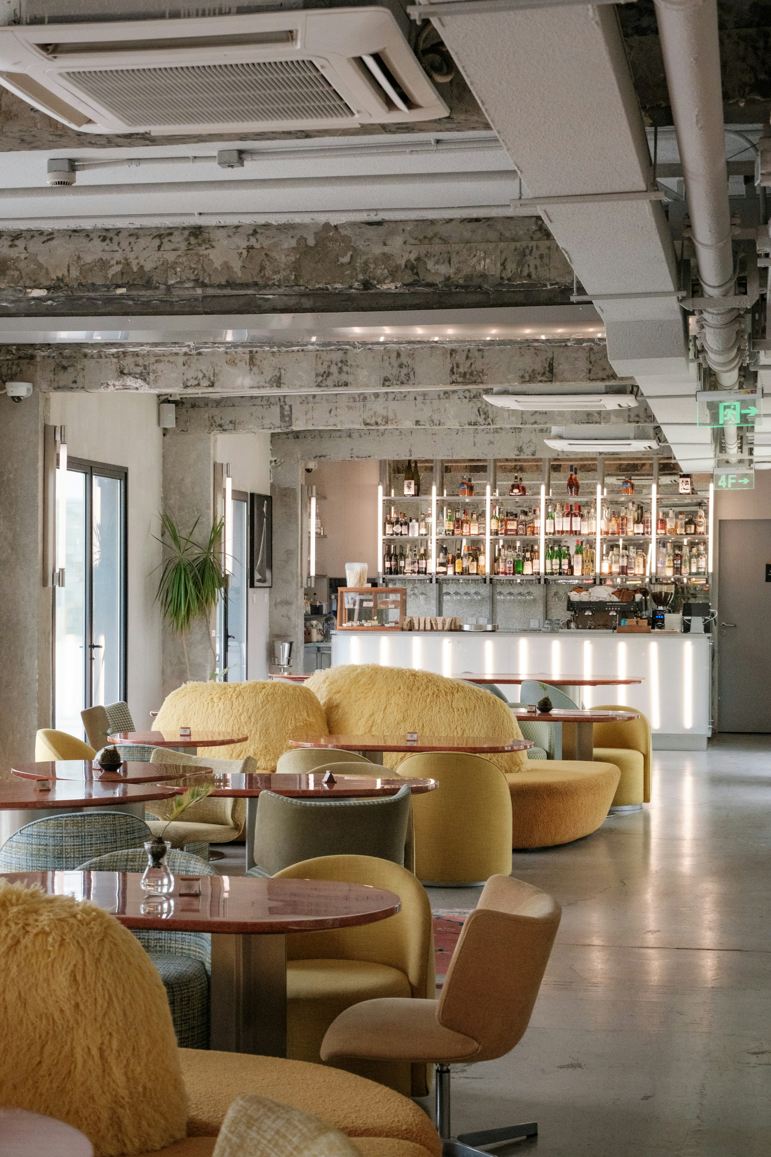 Sunlit Lounge: A Modern Café Scene with Velvet Armchairs and a Glass Bar