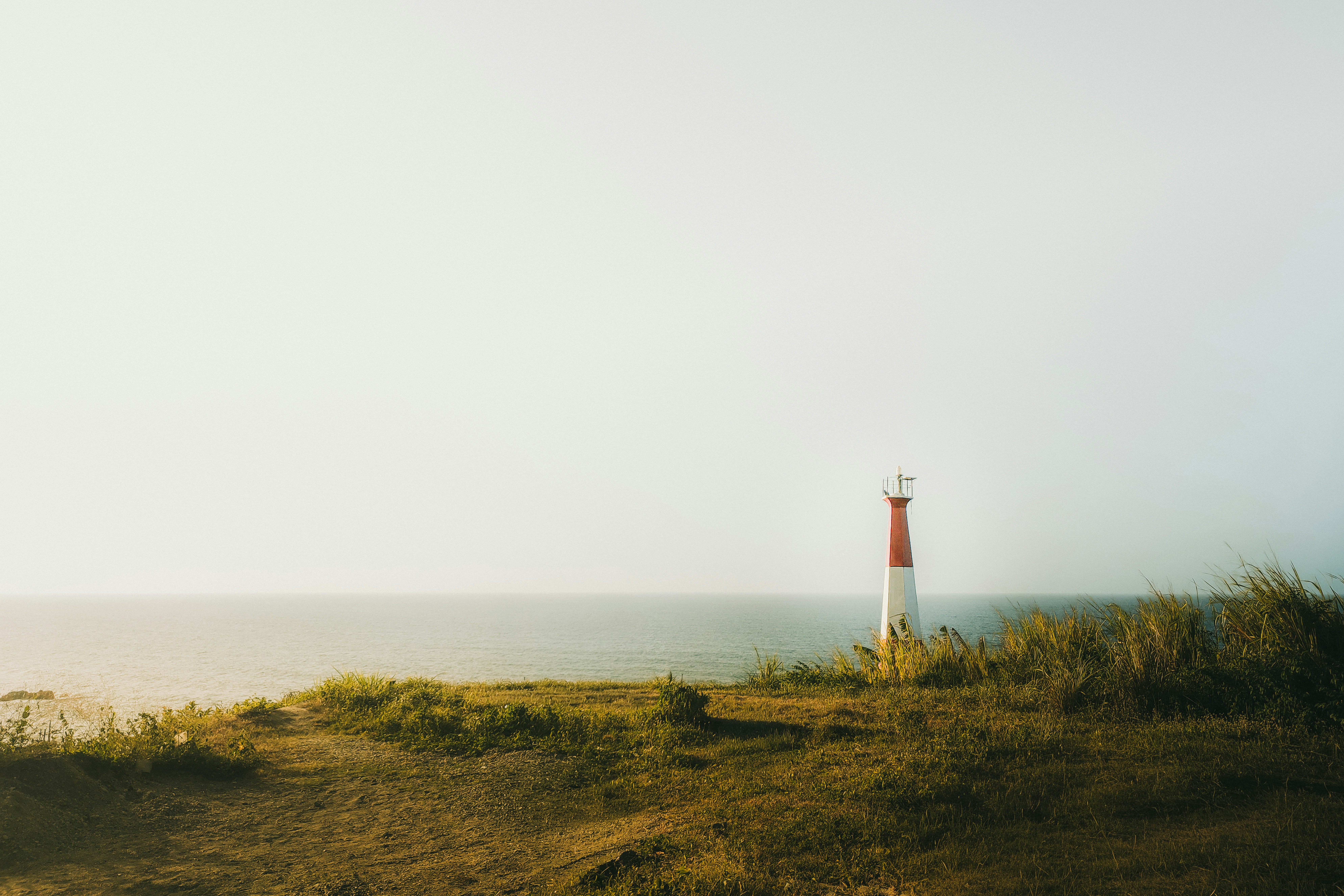 Coastal Sentinel: A Quiet Lighthouse Amid Dunes at Distant Light