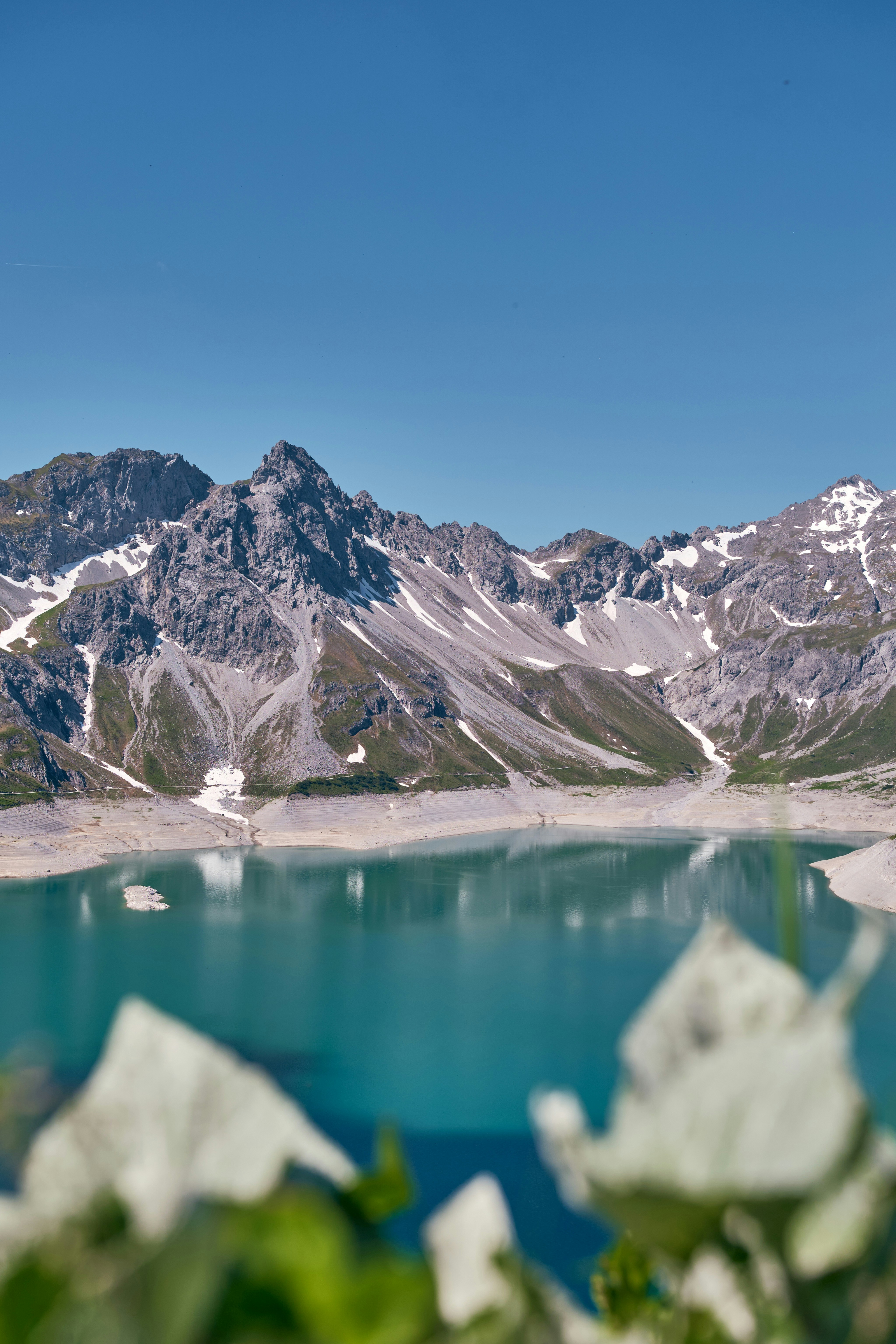 Azure Alpine Mirror: Snow-dusted Peaks Reflected in Glacier Lake
