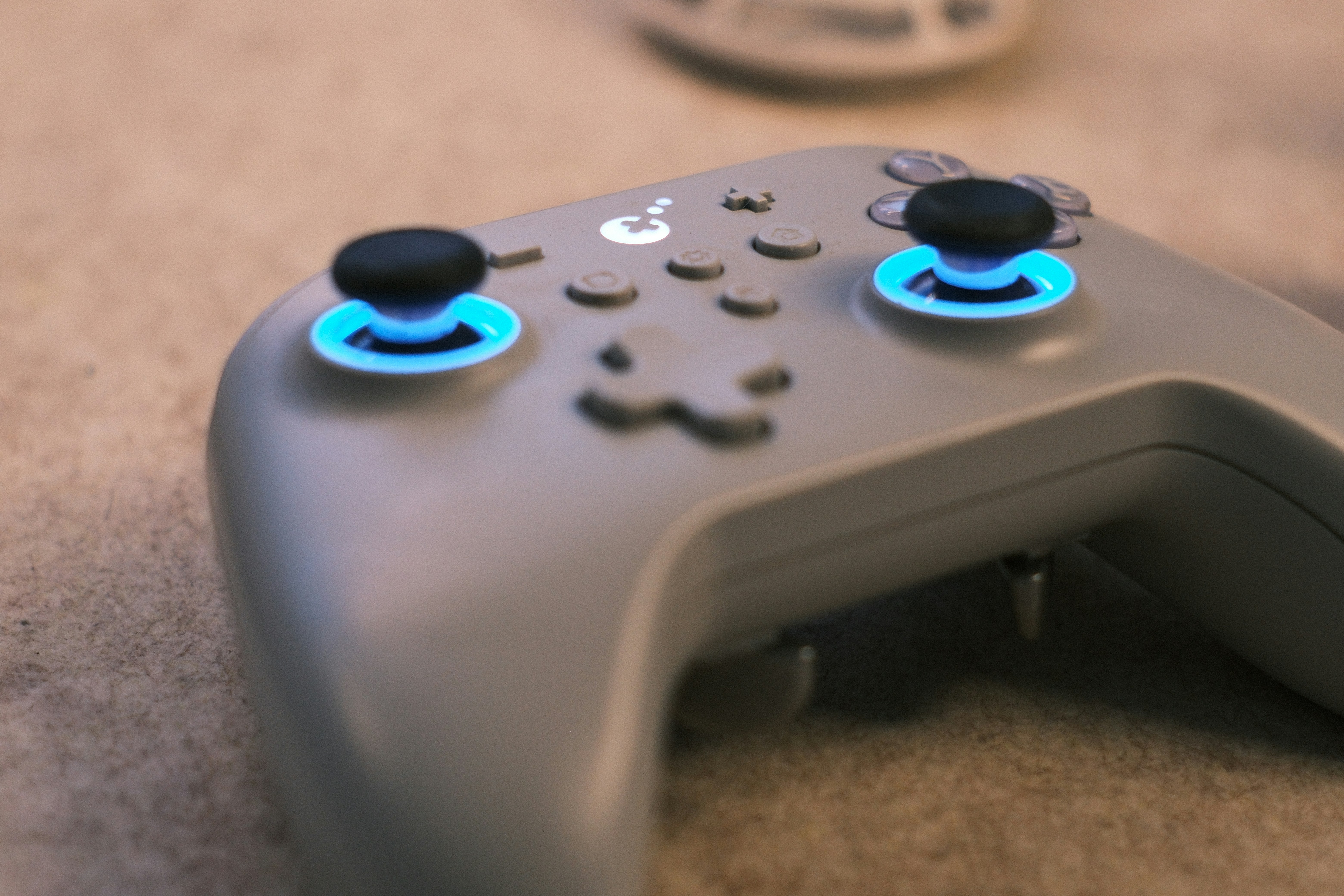 Blue-tinged Button Rings: A Gamepad Close-Up on Soft Surface