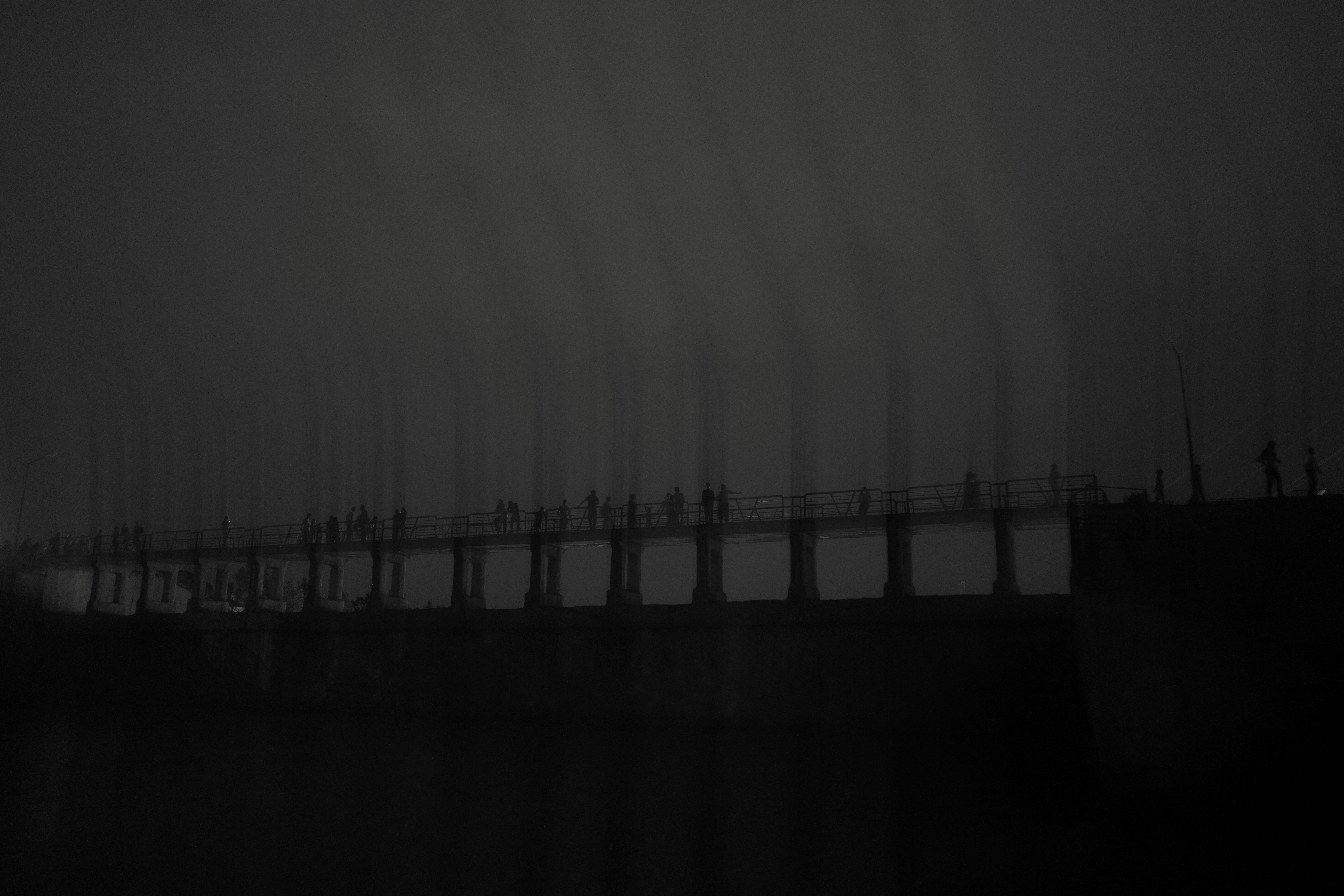 Silhouetted Pier at Dusk: A Grainy Walk to the Horizon