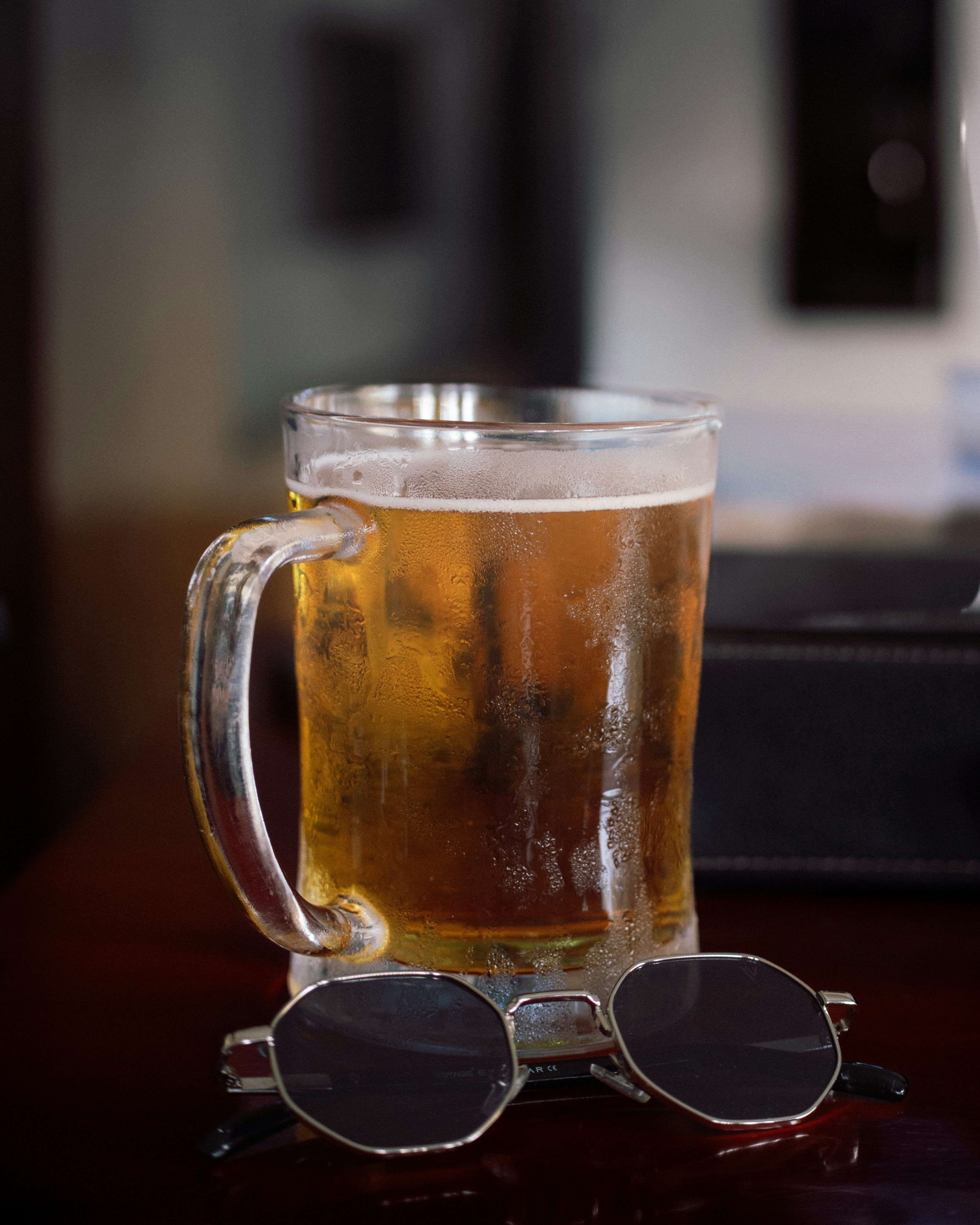 Amber Brew Reflections: A Glassy Moment with Sunglasses