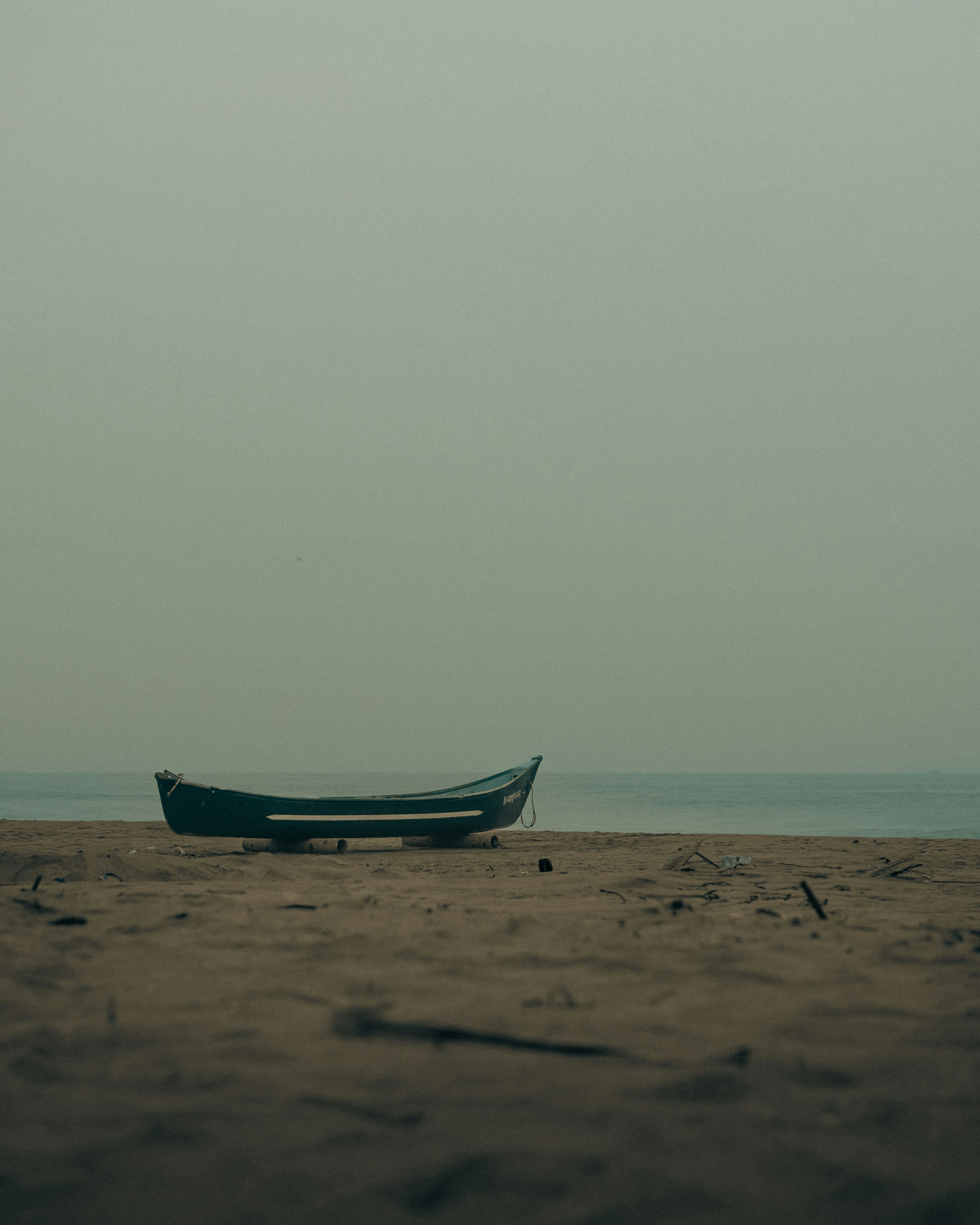 A solitary fishing boat resting on the sands of Gokarna, framed by the calm shoreline and endless horizon. A quiet reminder of the rhythm between land and sea.