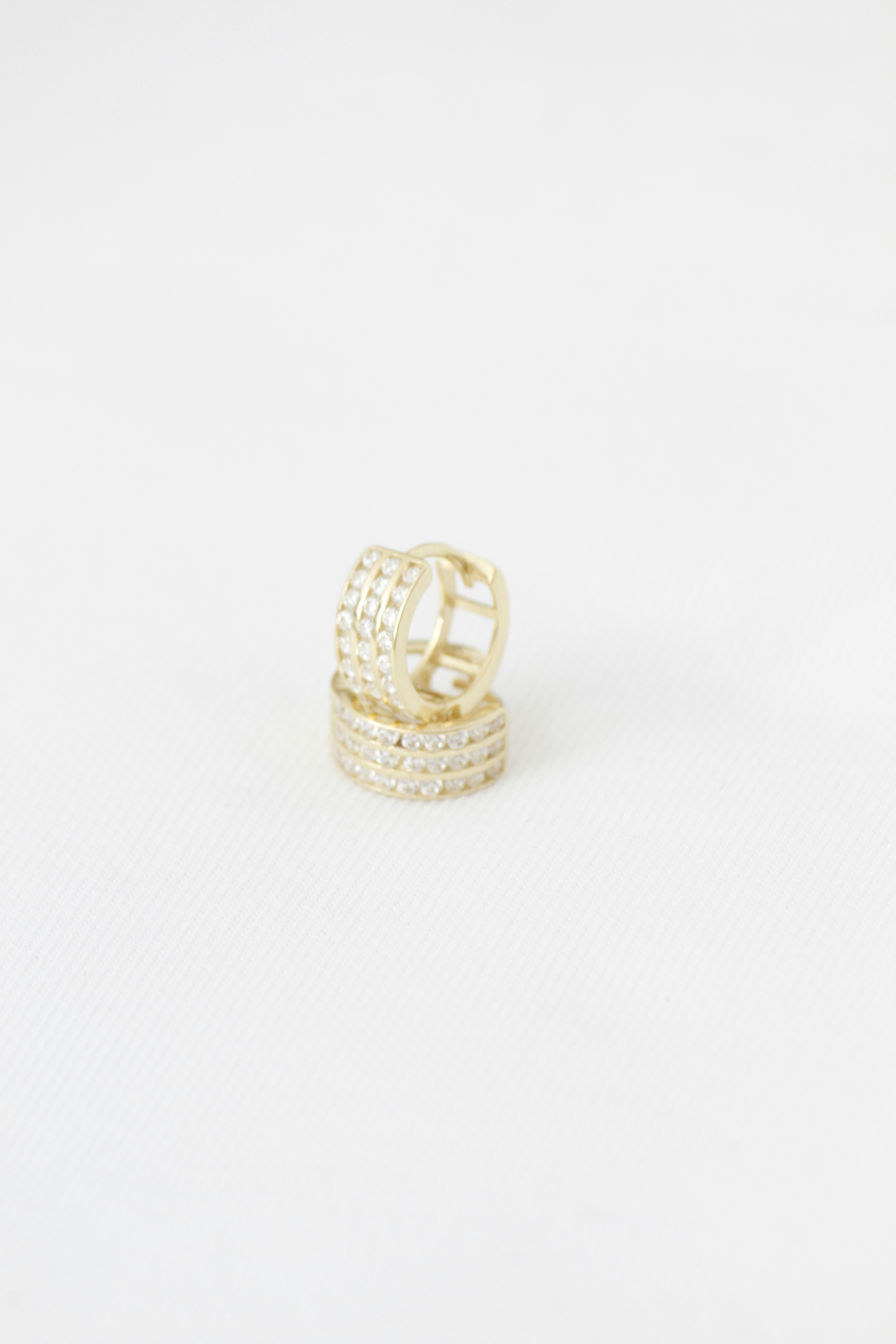 Stacked gold rings: a delicate still-life against a bright canvas