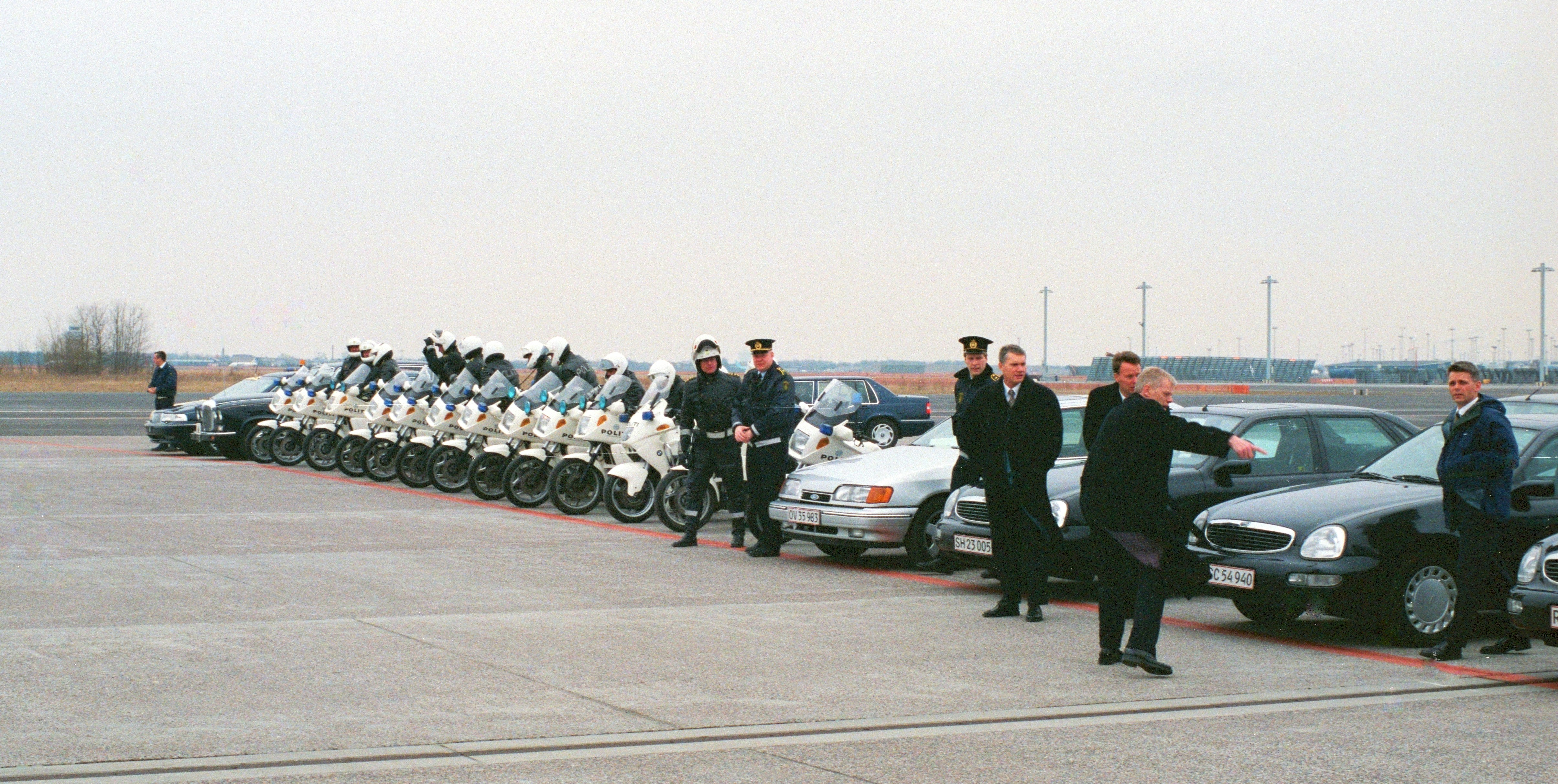Line of Police Motorbikes and Officers in a Parking Lot