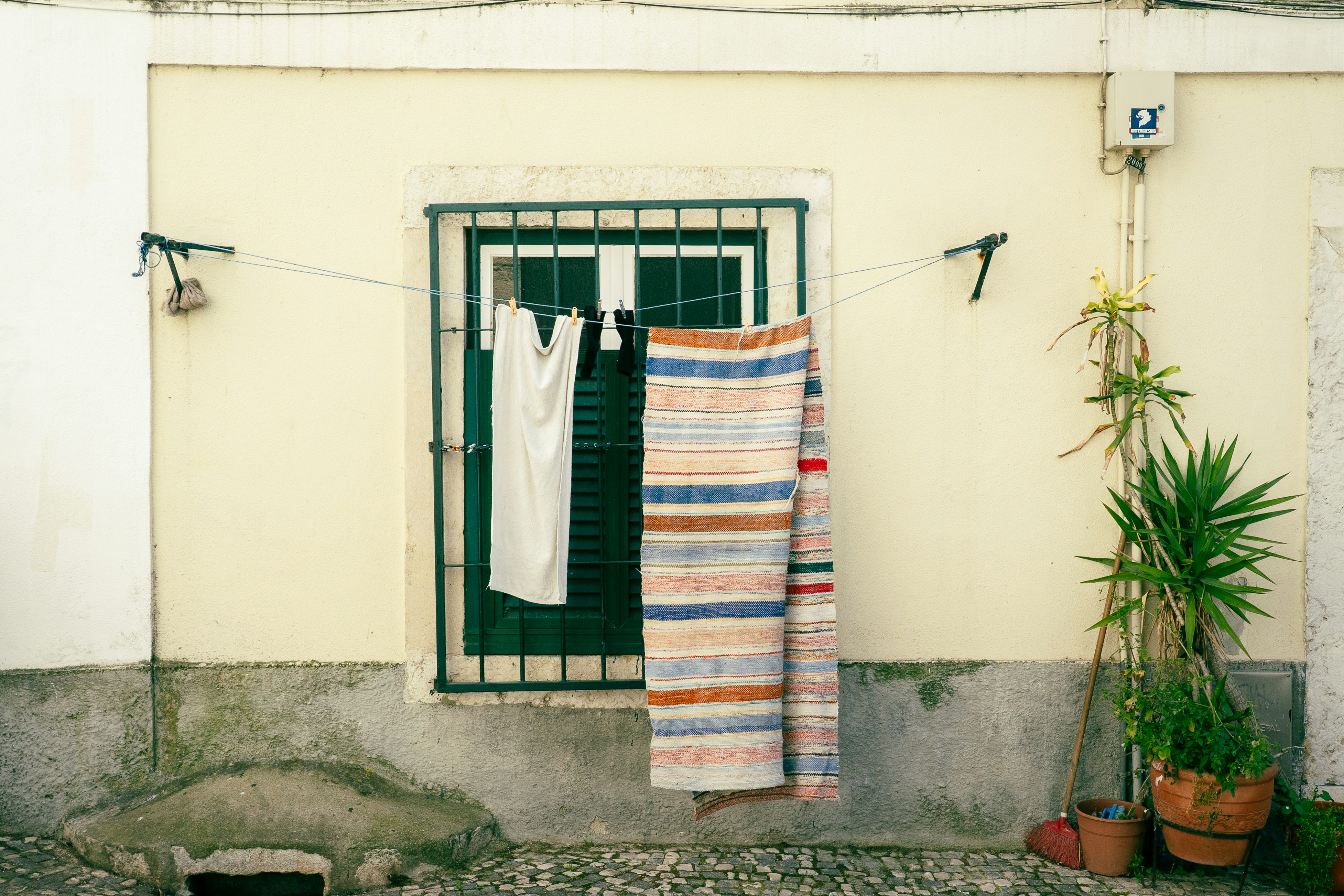 Clothesline Portrait: a sunlit doorway framed by a striped blanket