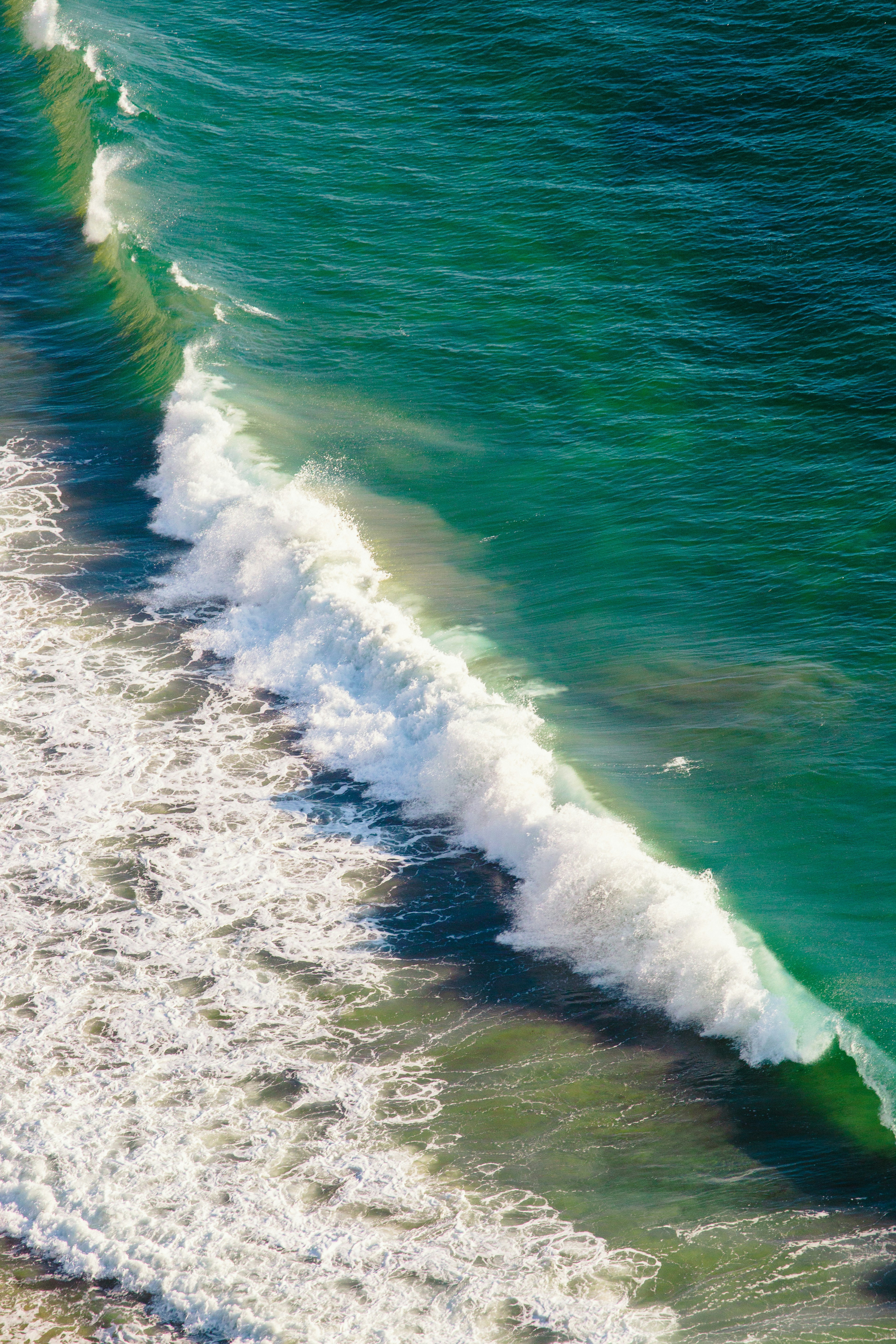 Aerial Crest: Aquatic Currents Rolling Along the Shore