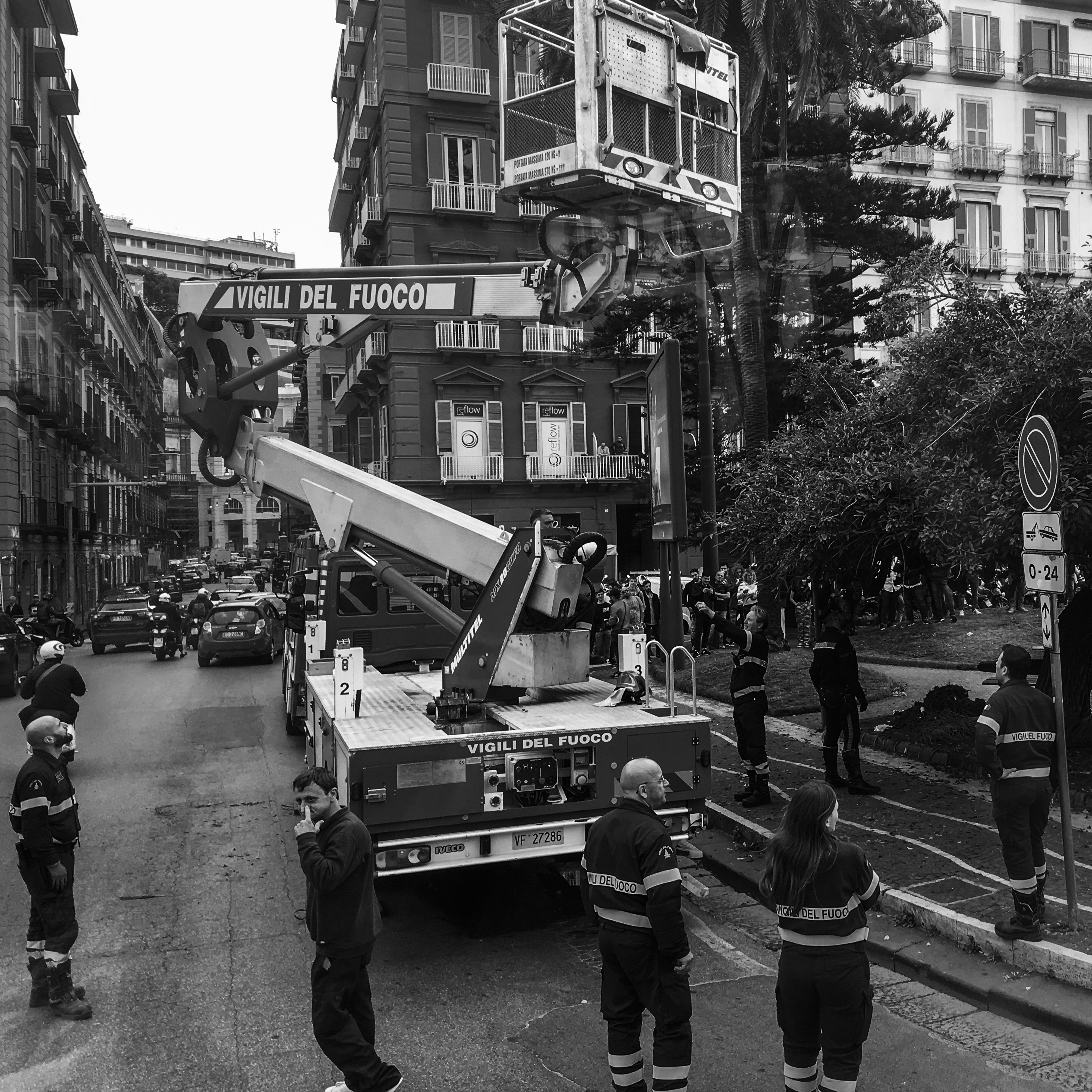 Emergency Crew in Action: Fire Truck Crane Over a Narrow City Street