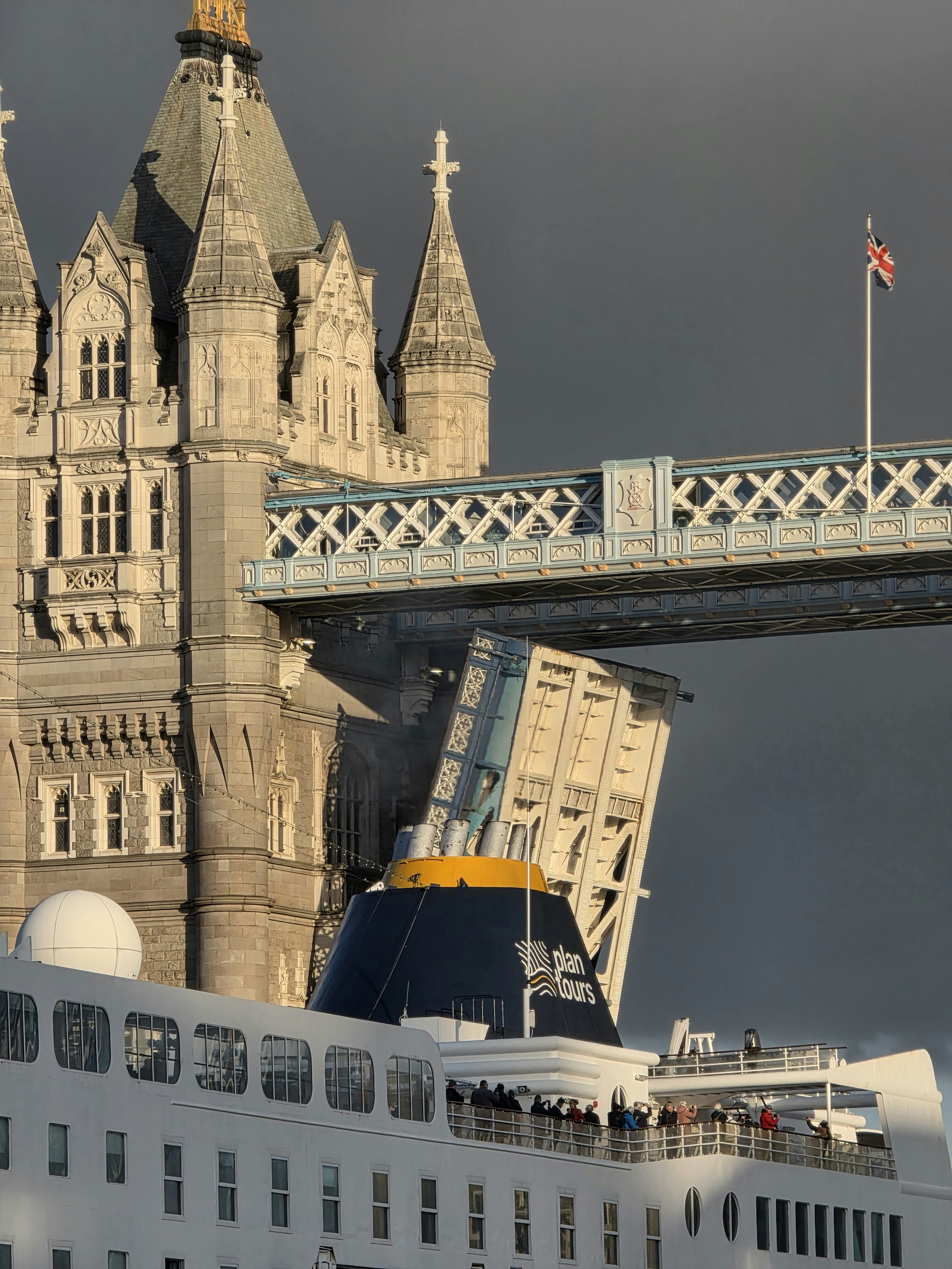 Tower Bridge's Majestic Silhouette: A Cruise Ship Under Quiet Storm