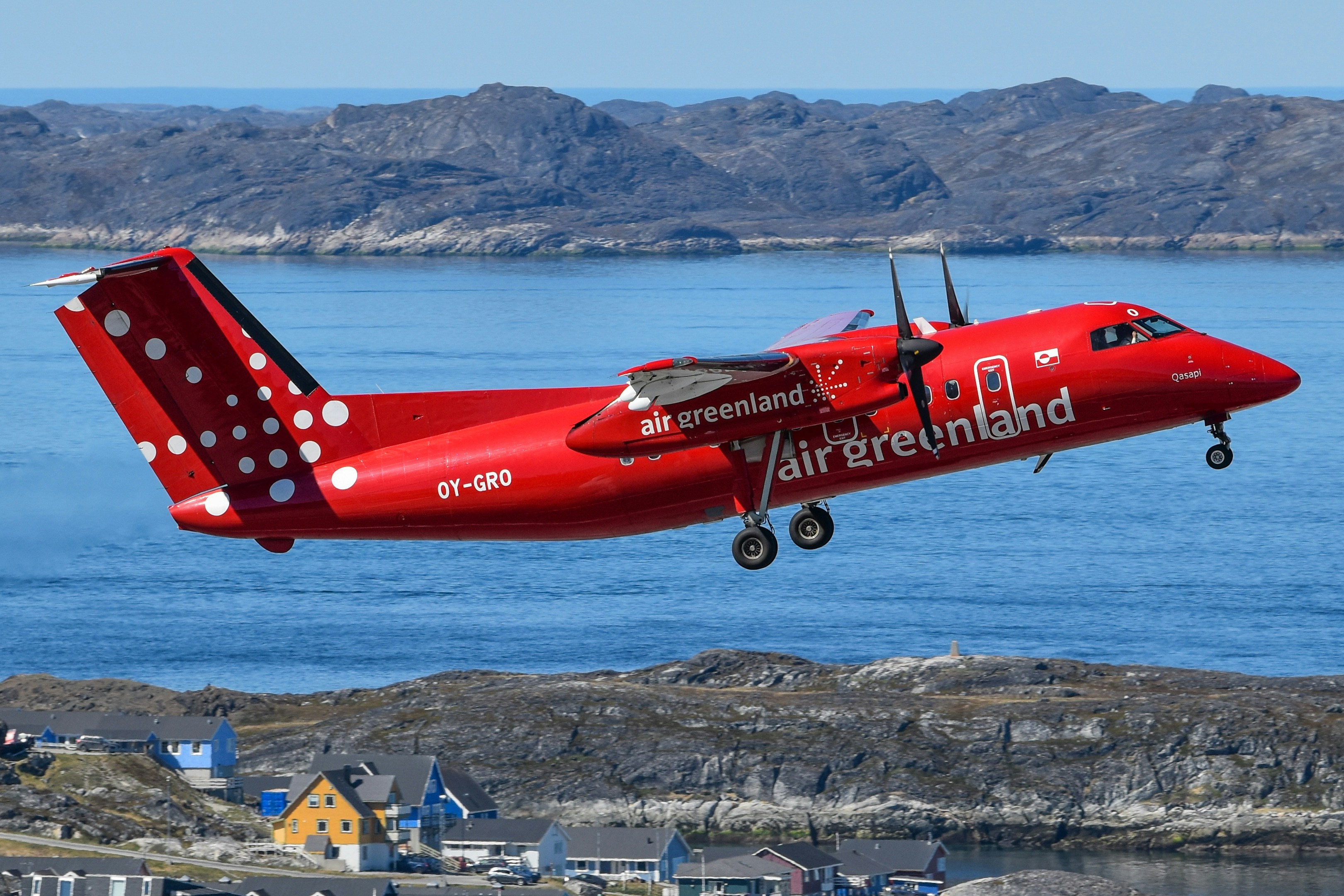 Crimson Skies: Air Greenland Dash Soaring Over Fjord Town