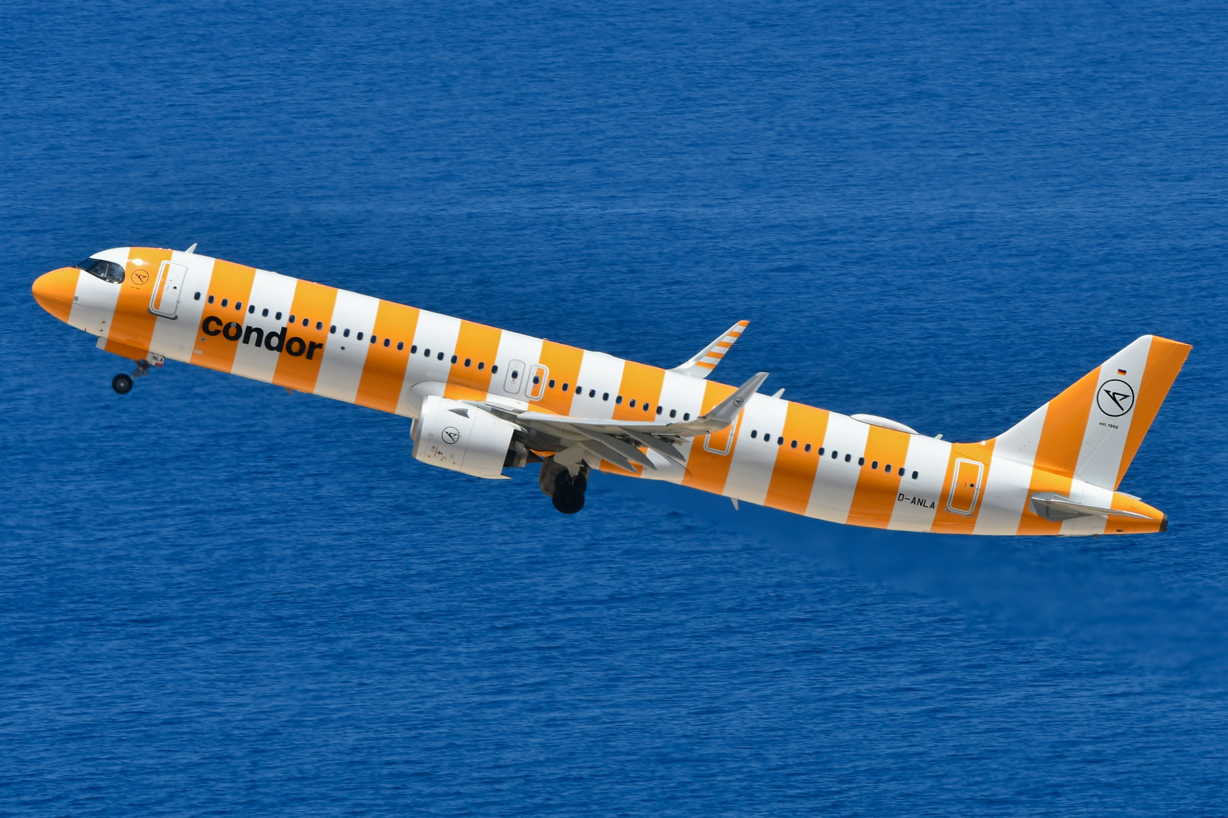 Striped Condor: A bright fuselage slicing through blue seas