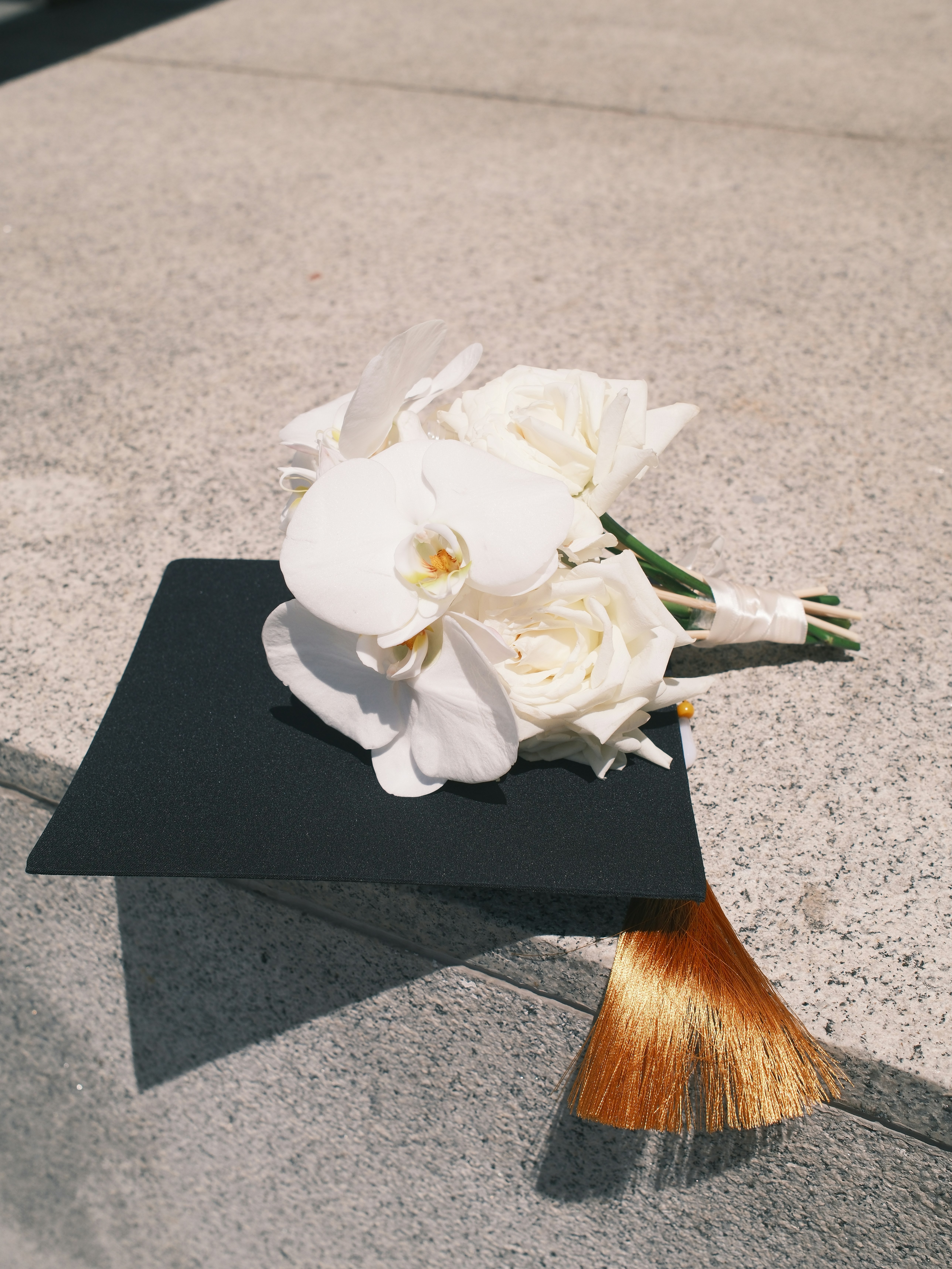 White bouquet on a graduation cap with brush stamp of light