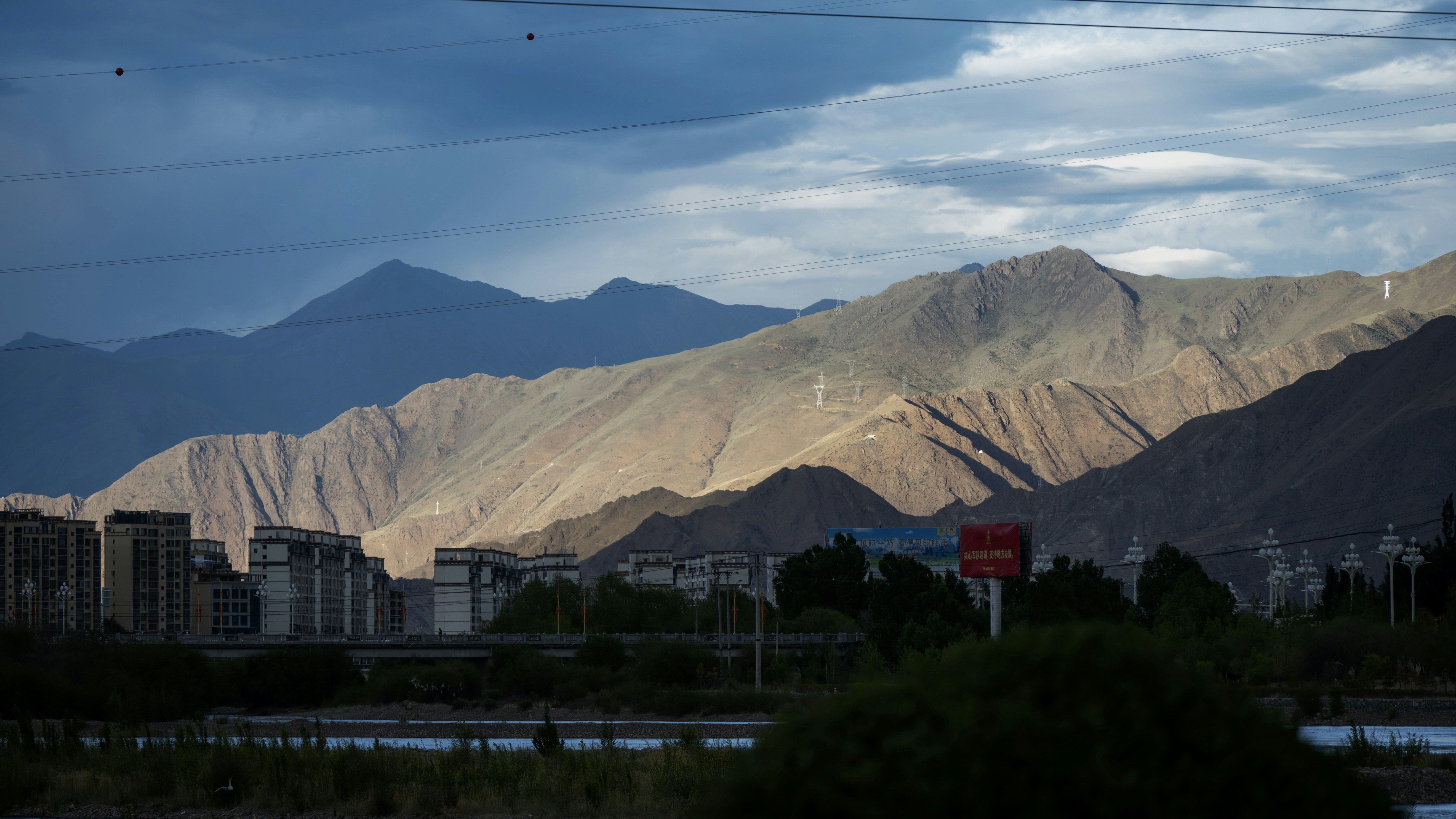 Sunlit Ridge Over the City: Mountains Casting Long Shadows