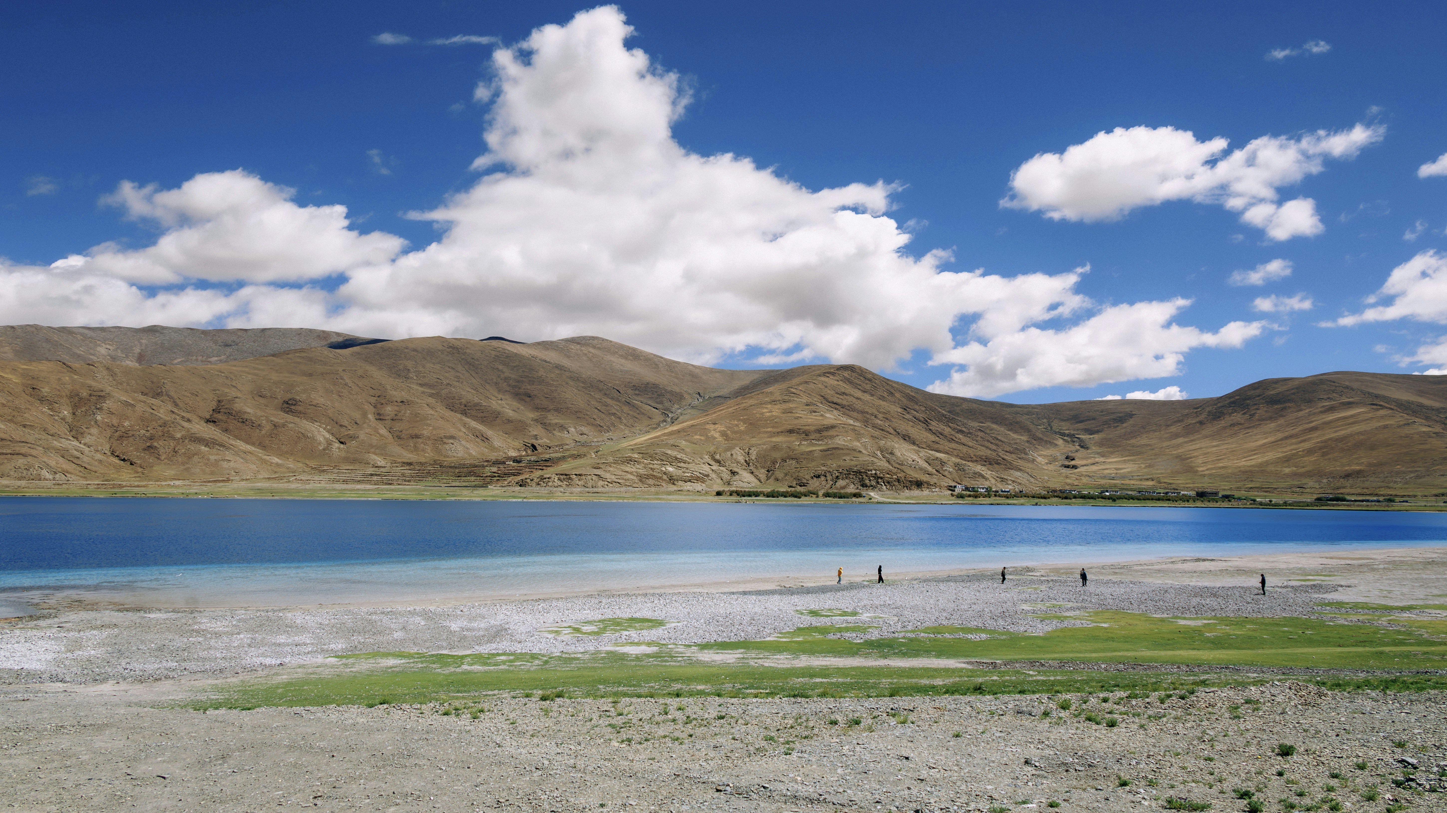 Azure Lake on sunlit slopes under a sky of puffy clouds