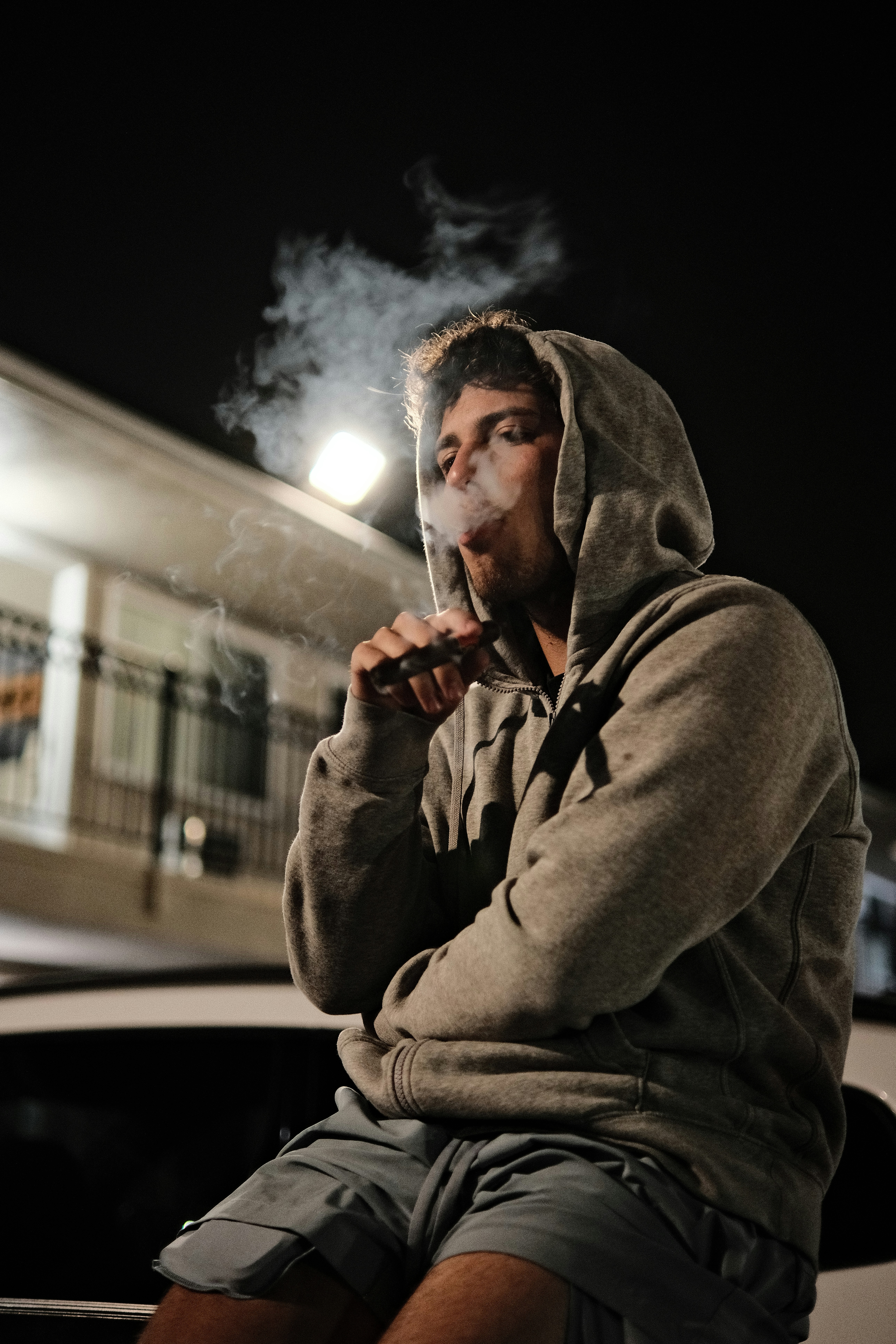 Night Smoke: A Hoodie-Clad Moment Under Street Light