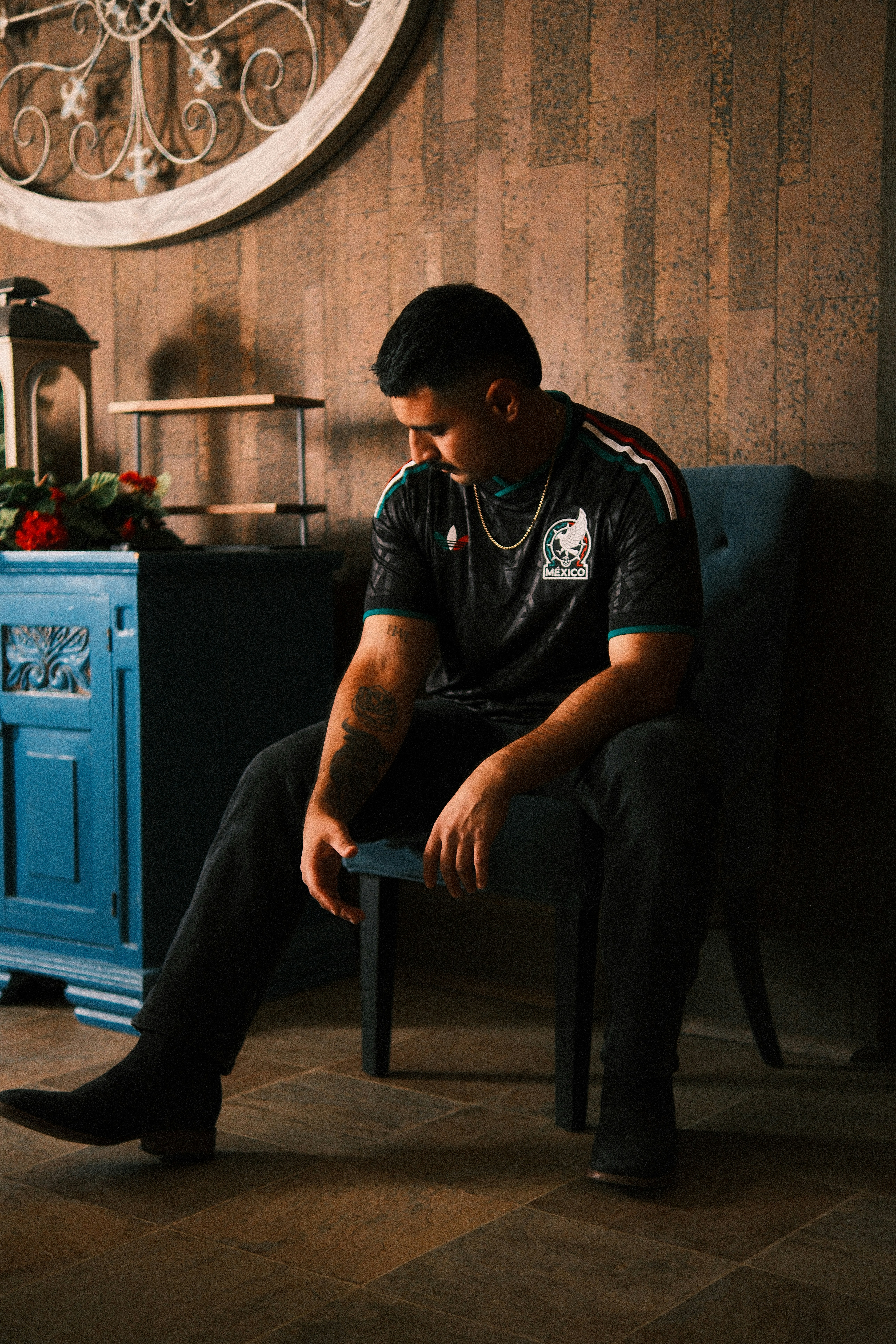 Quiet Moment in the Lounge: A Man in a Mexico Soccer Jersey Loosely Pauses