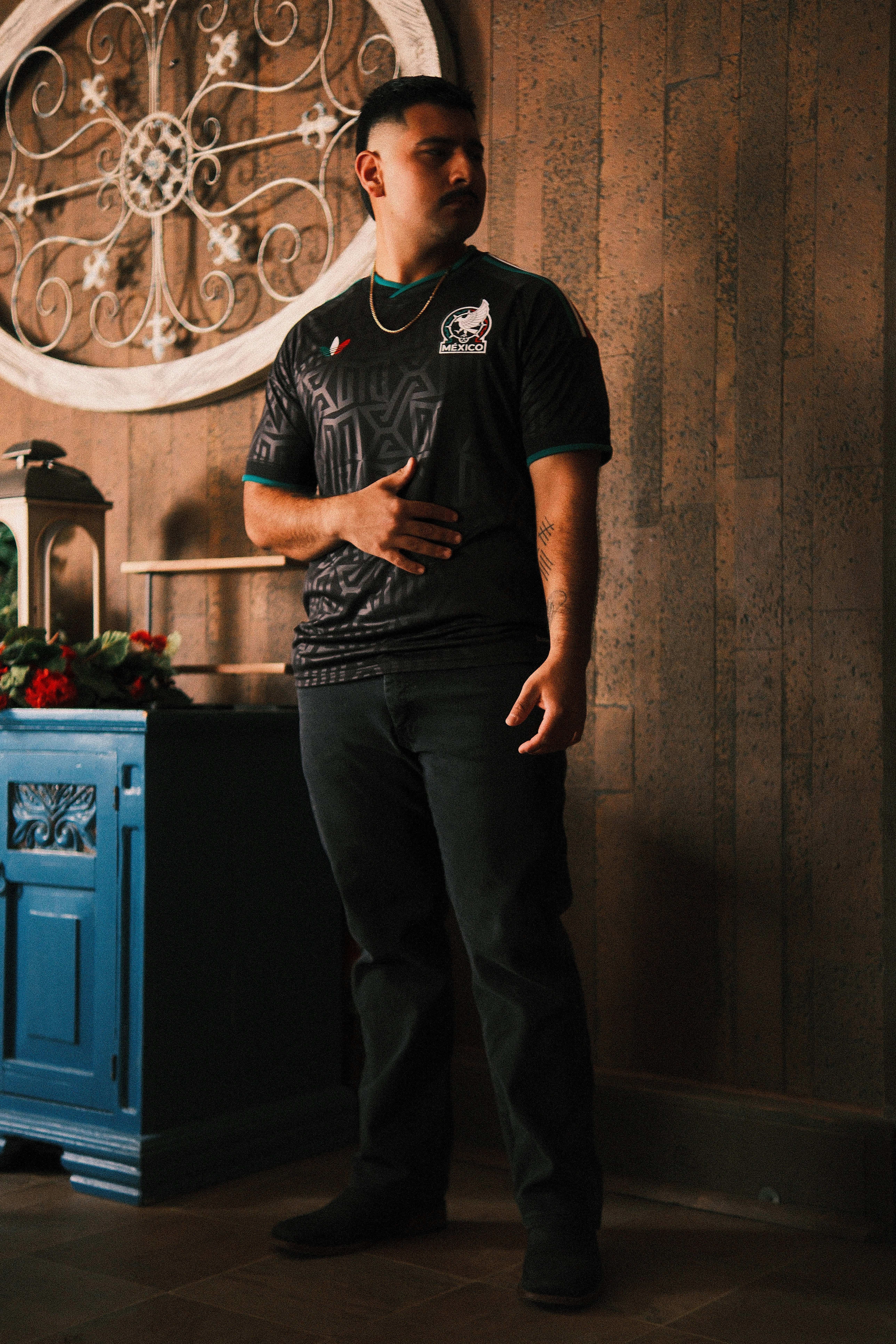 Portrait in a Warm Wall Studio: A Confident Stance by the Blue Cabinet