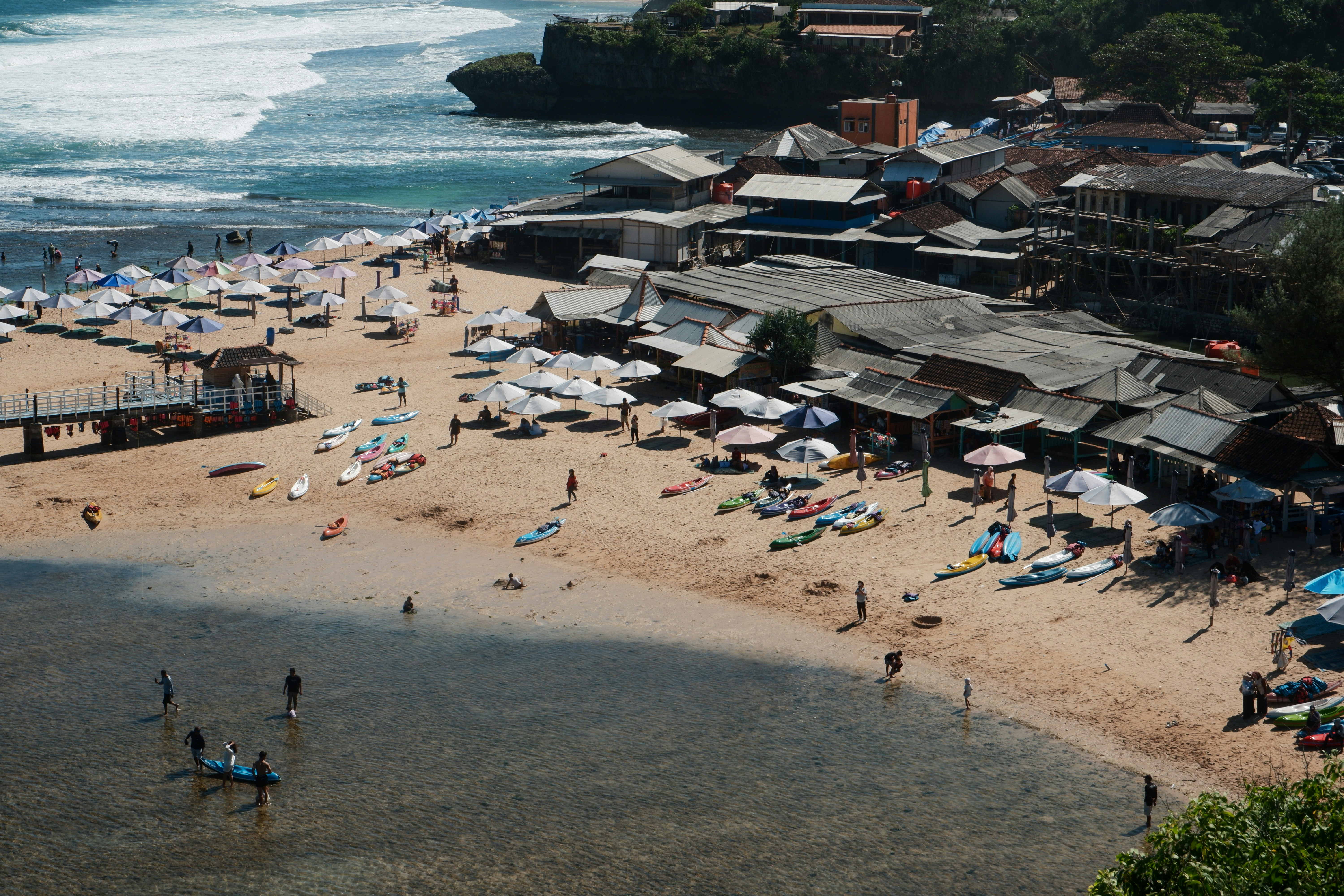 Sunlit Strand Bustle: Beachfront Shafts of Umbrellas and Boats