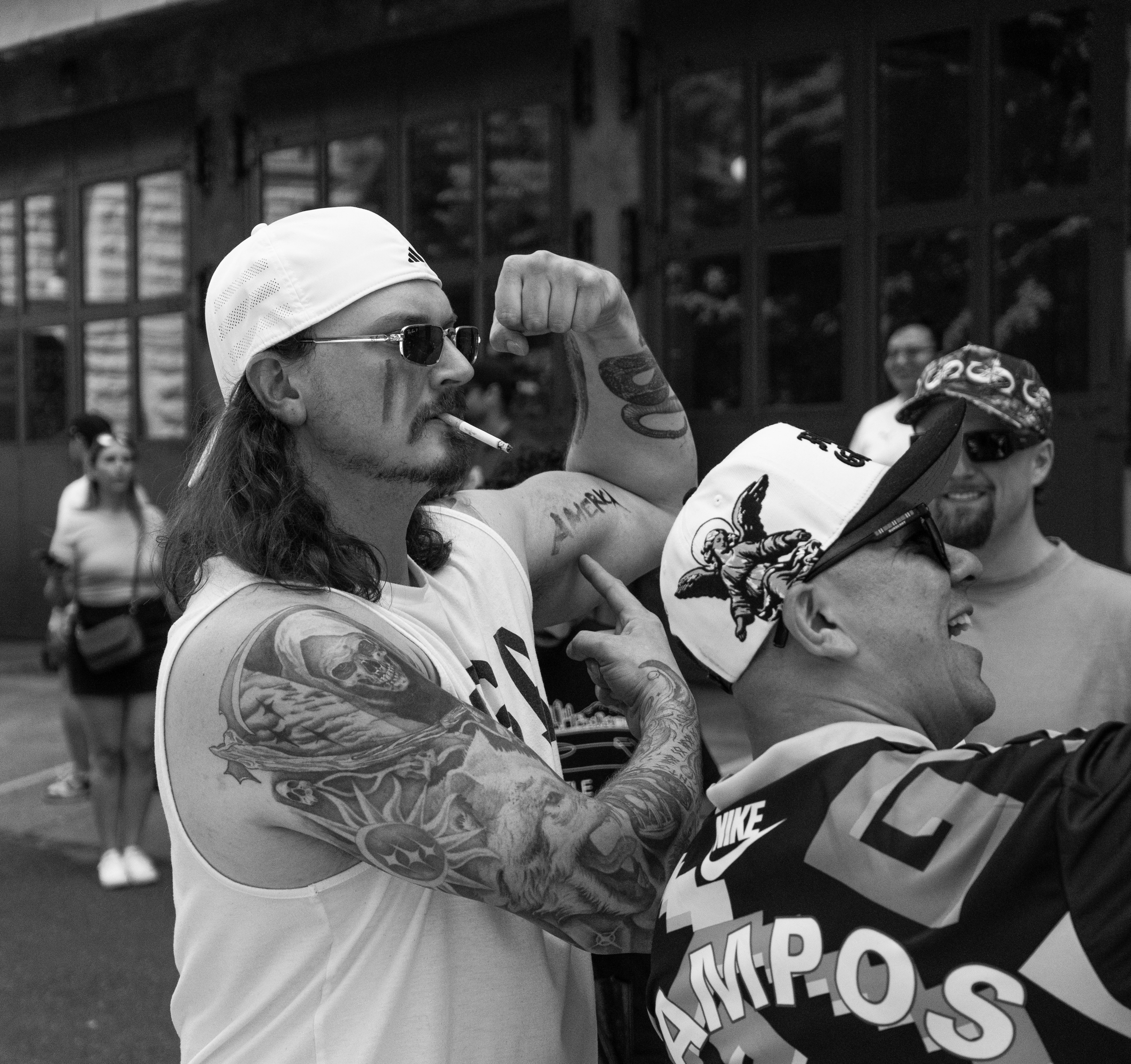 Cigarette Break Under Dark Glass: Tattooed Friends Rally at the Bar
