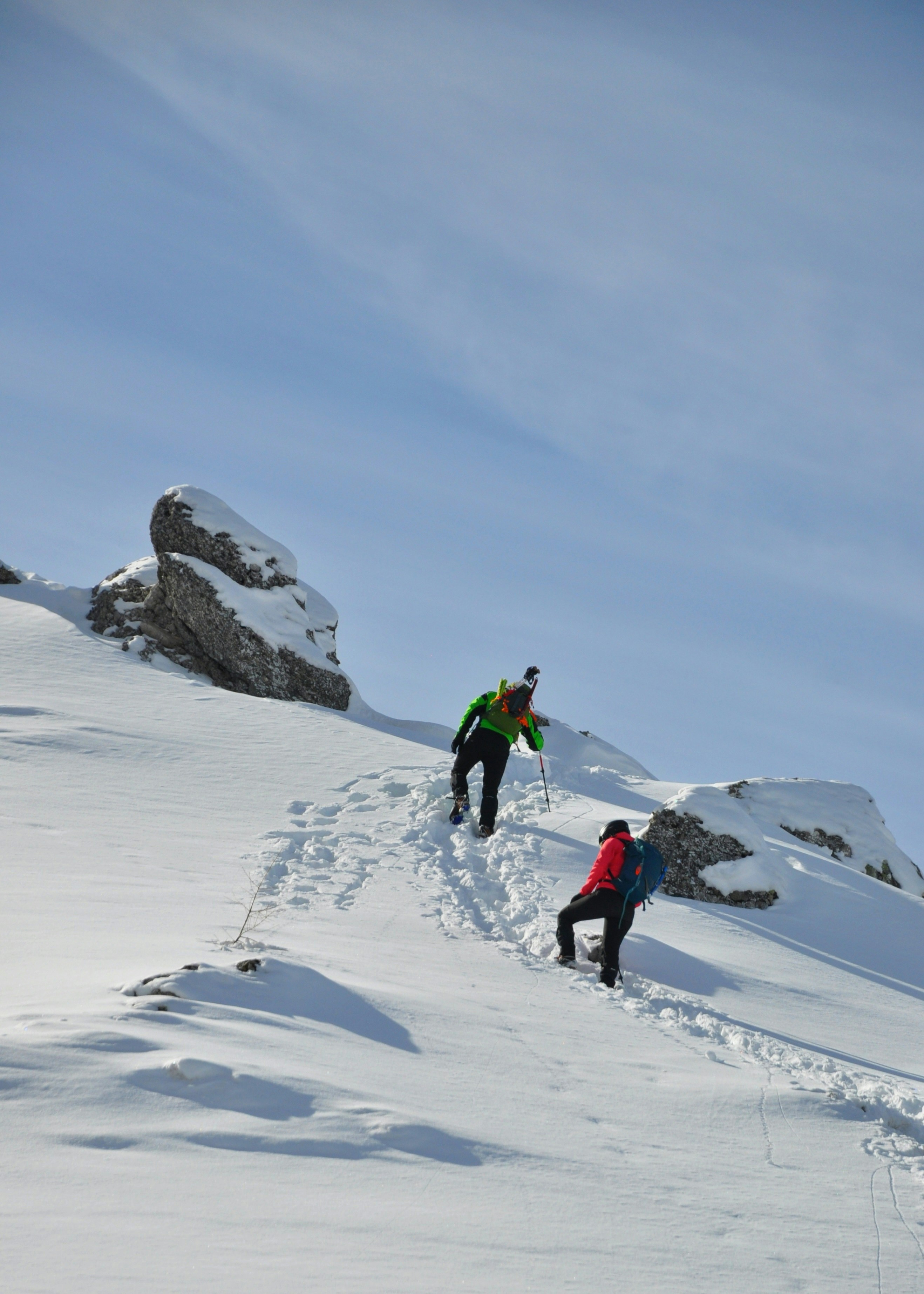 Climbers Ascend a Snow-Covered Ridge Under a Clear Blue Sky