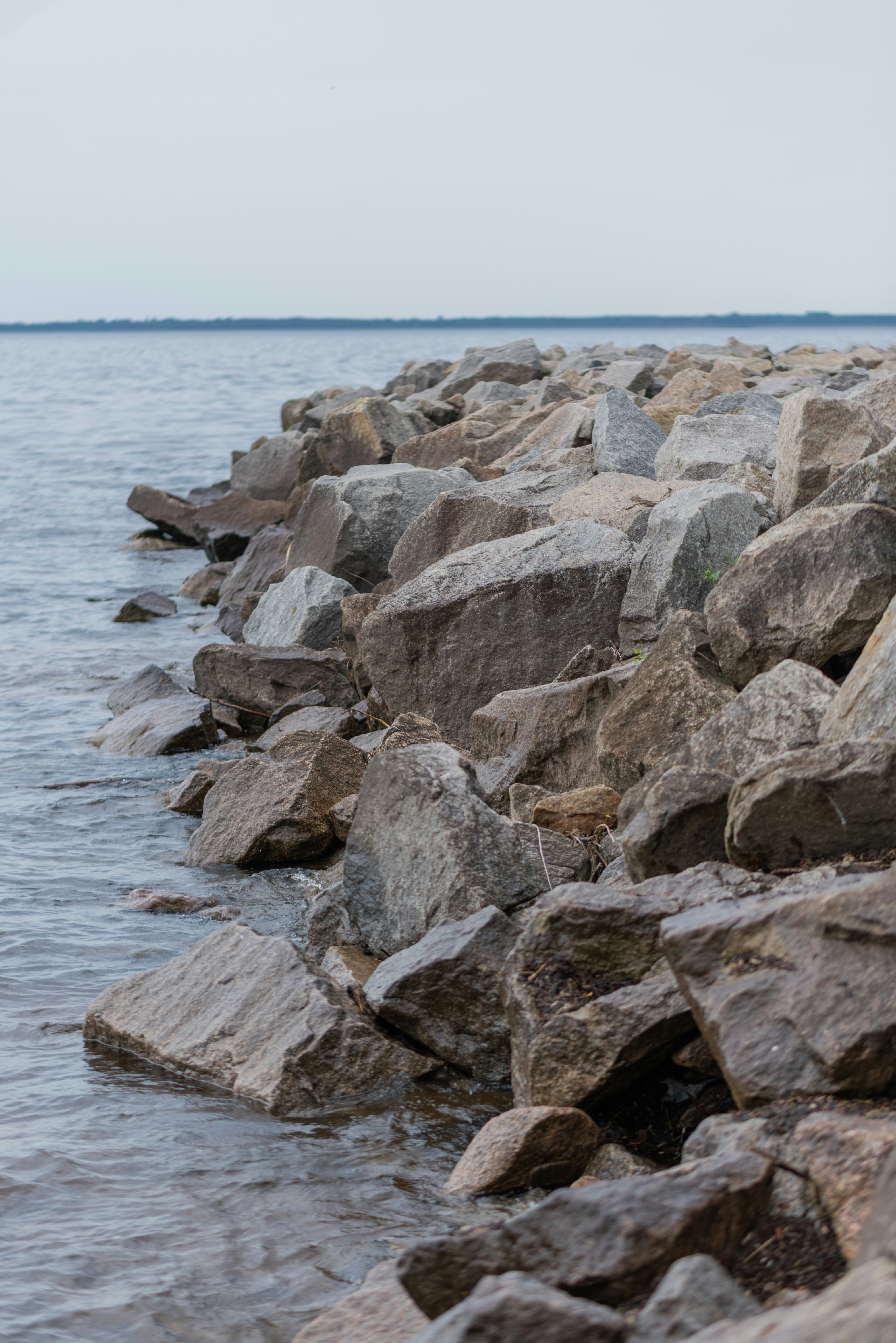 Rocky Breakwater Stretching into a Calm Lake