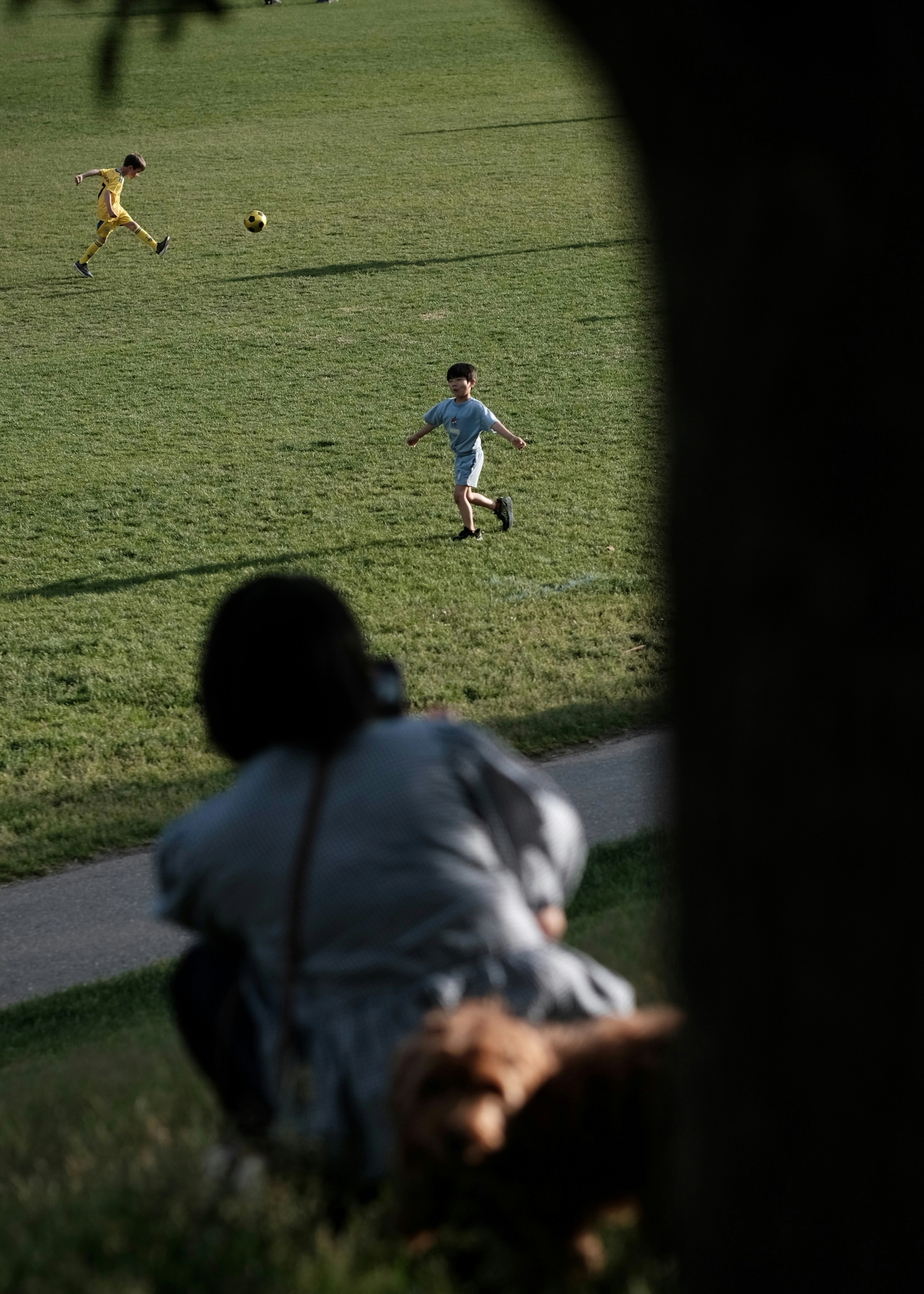 Youthful Play on Open Field Framed by Shaded Arch