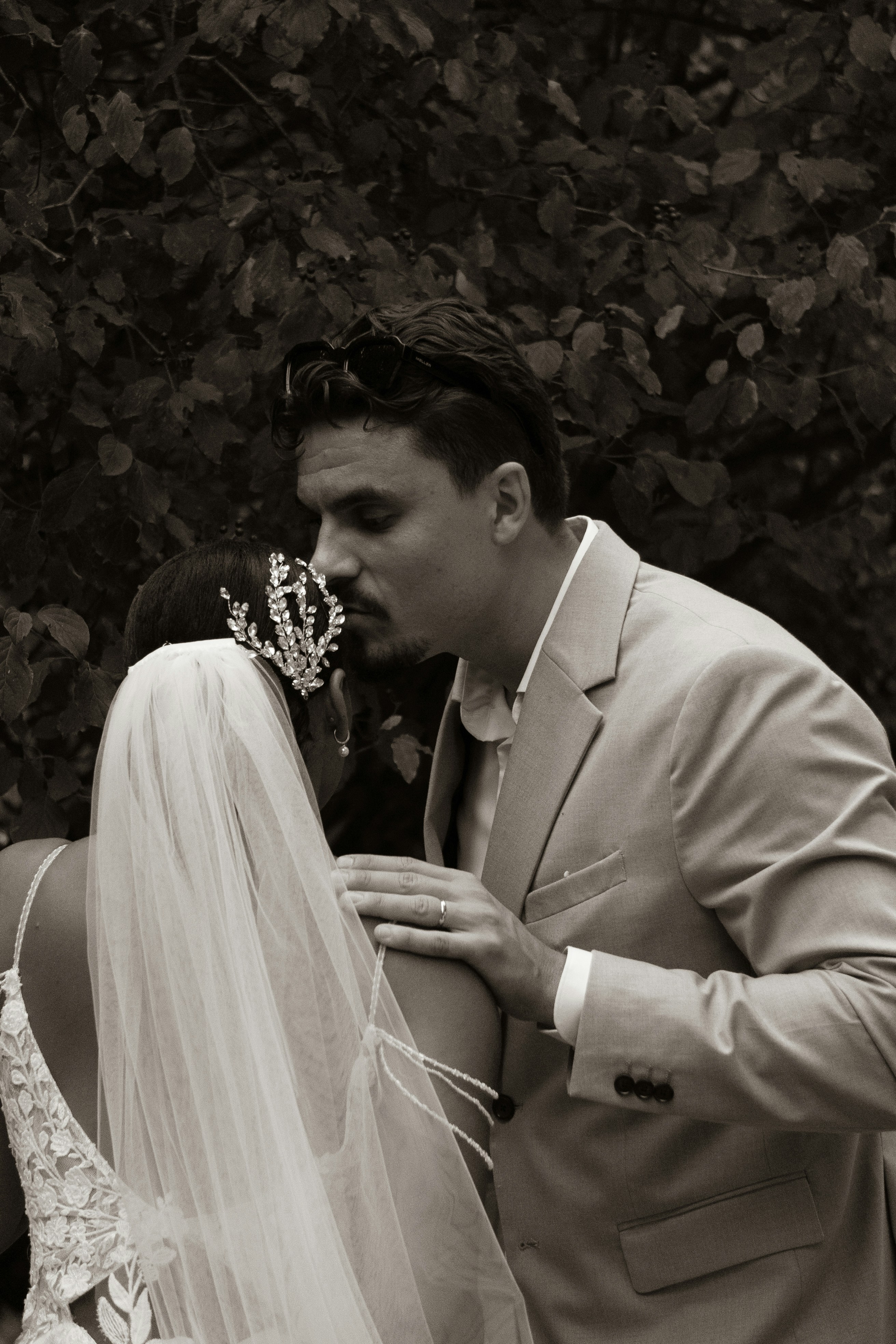 Veiled kiss of union beneath a garden veil