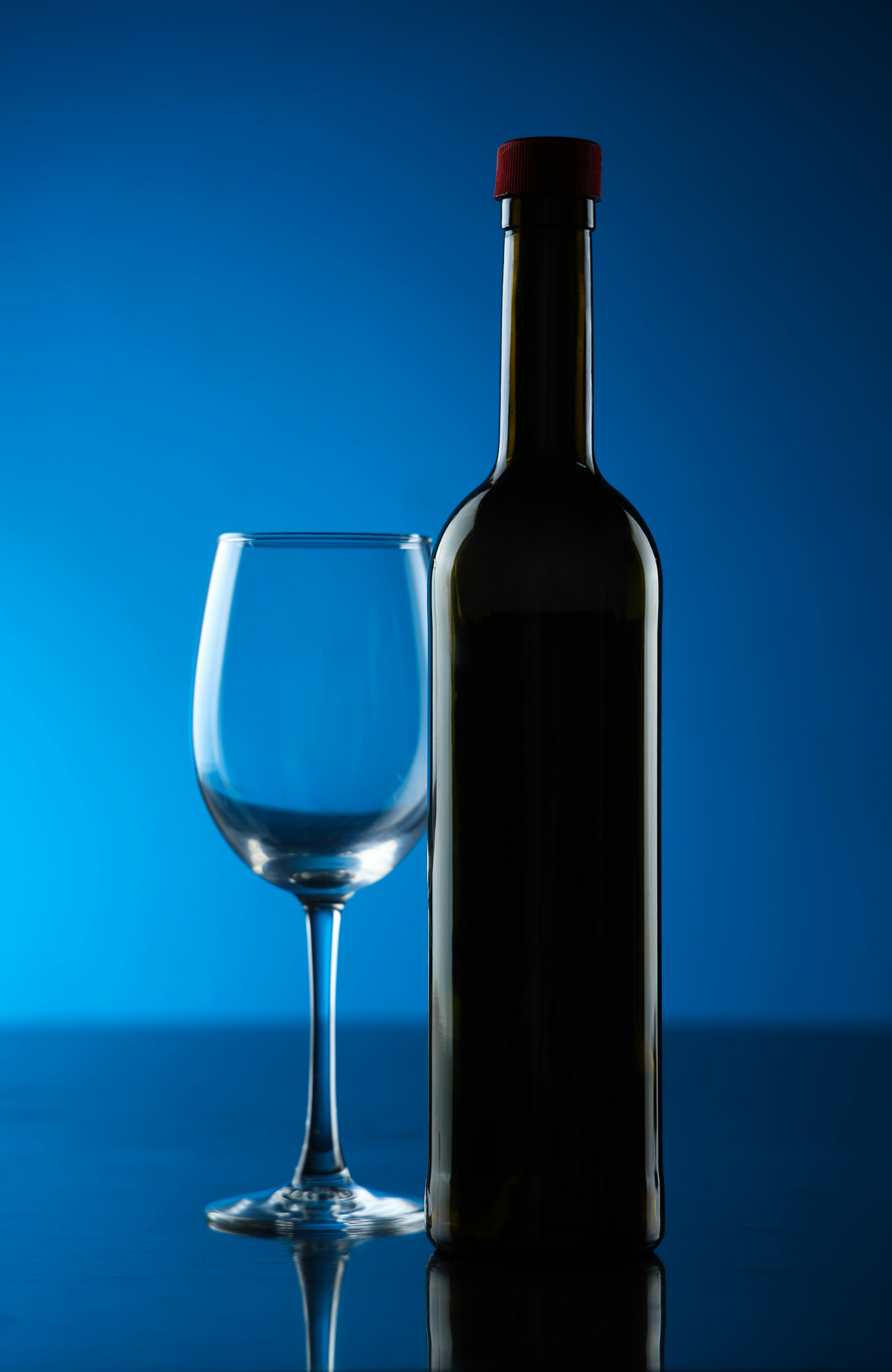 Elegance in Cast Shadow: A Bottle and Glass in Quiet Blue