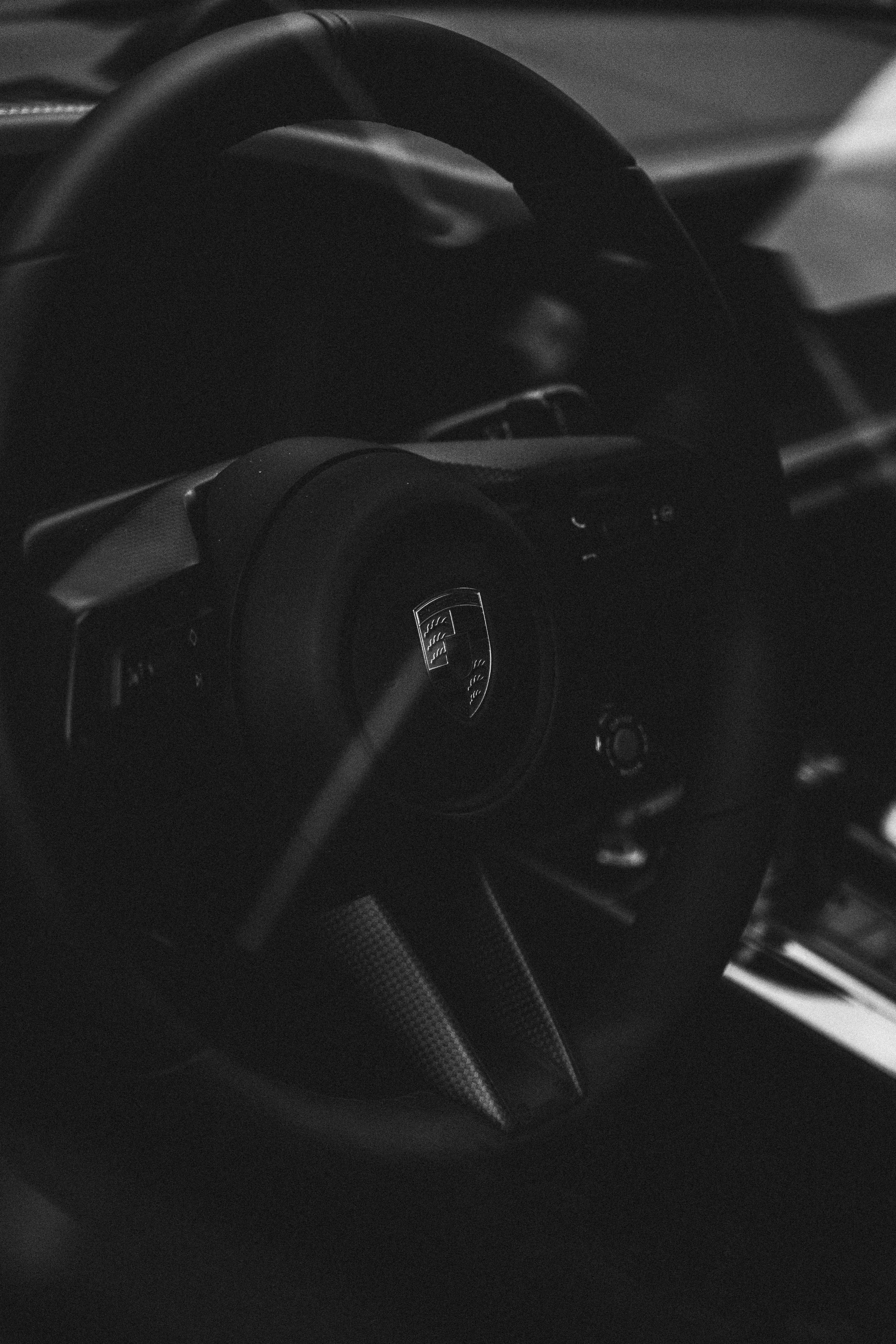 Black and white view of a porsche steering wheel.