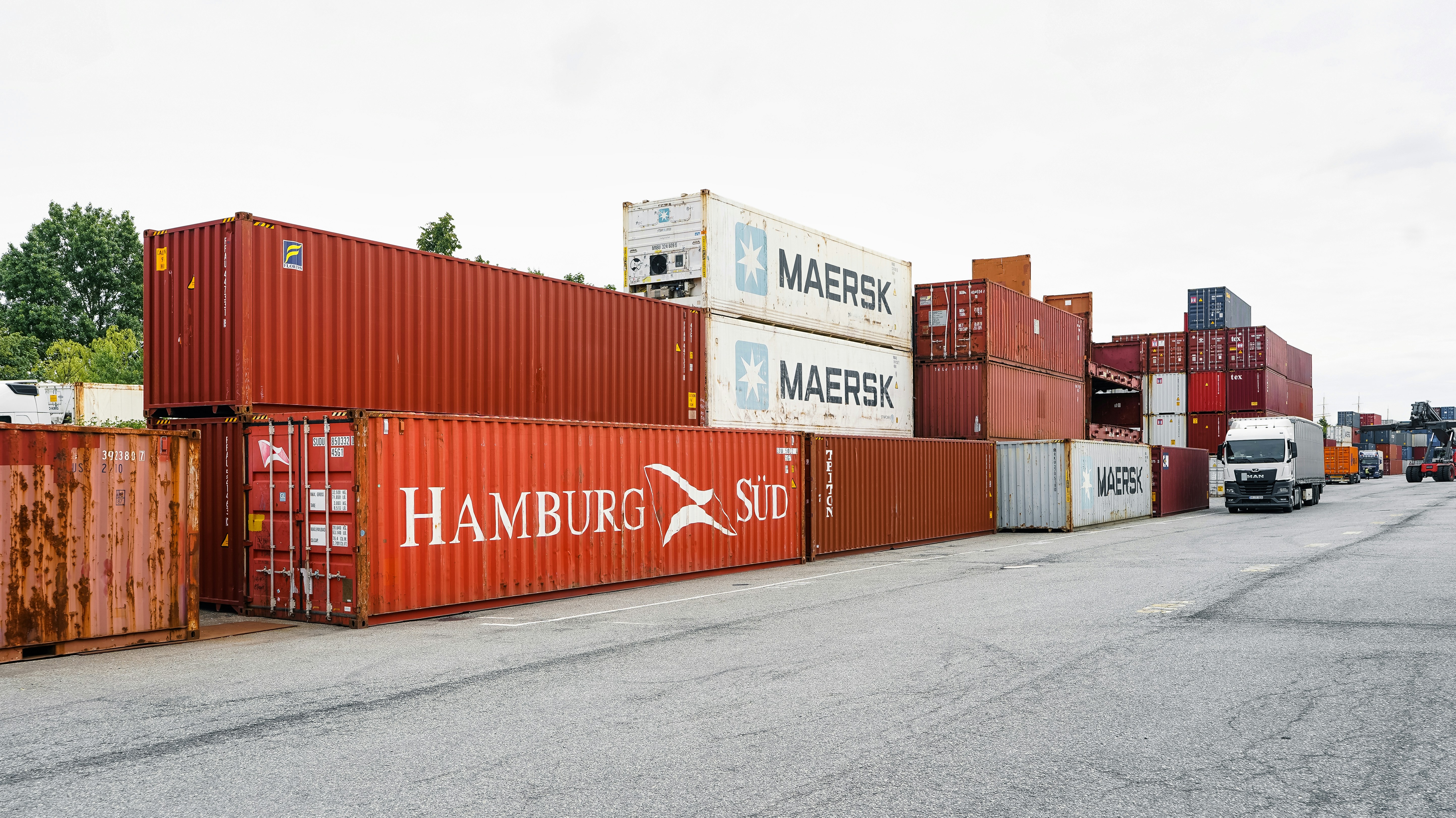 Staked Containers on a Harbor Lot: Distant Vans and Sky-Gray Asphalt