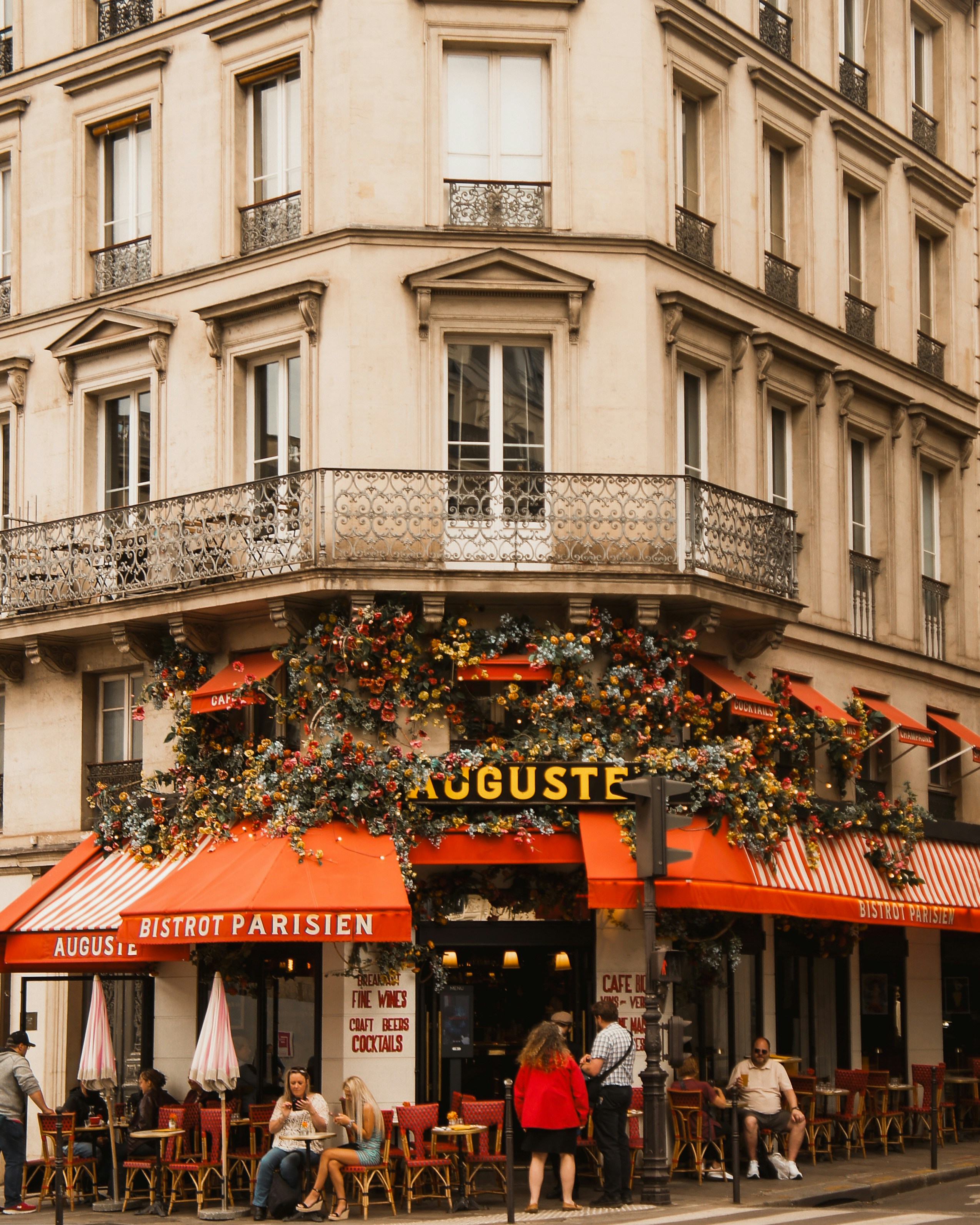 Parisian Bistro Bloom: A Corner Café Buzz Beneath a Floral Balcony