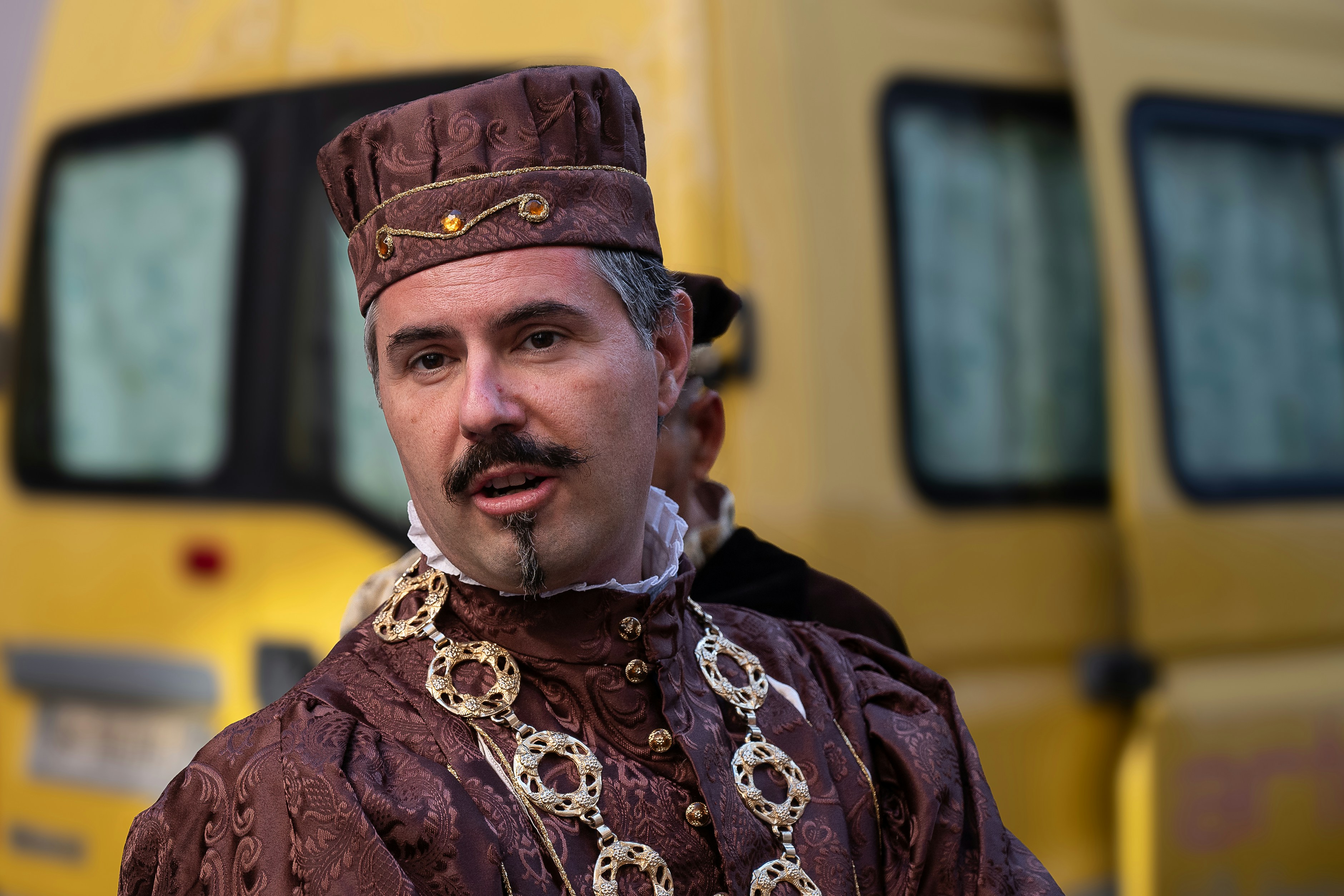 Regal Traveler: A Persian-inspired Attire Before a Yellow Transit Backdrop