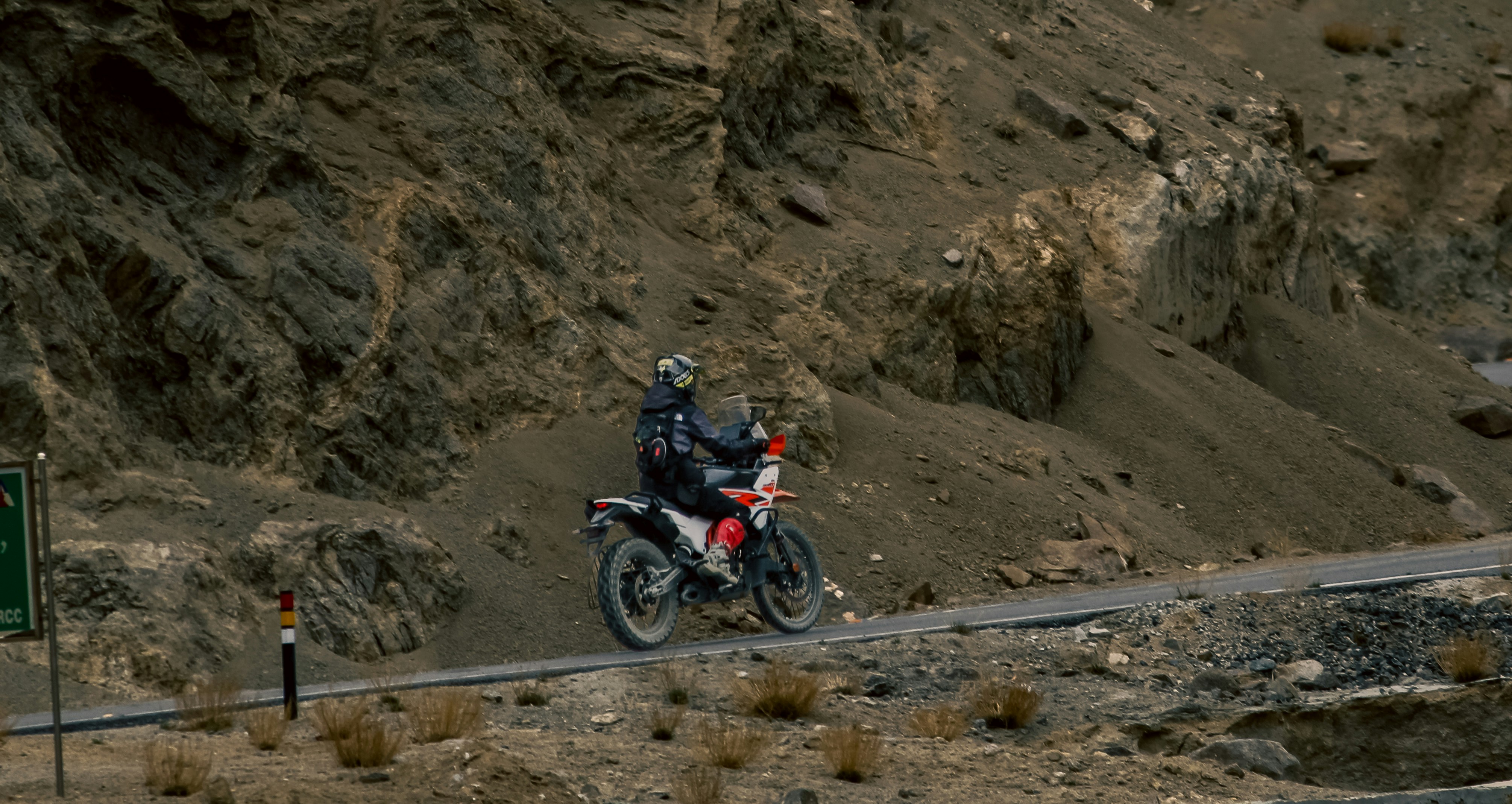 Rugged Ride: Motorcyclist Navigates a Winding Desert Road