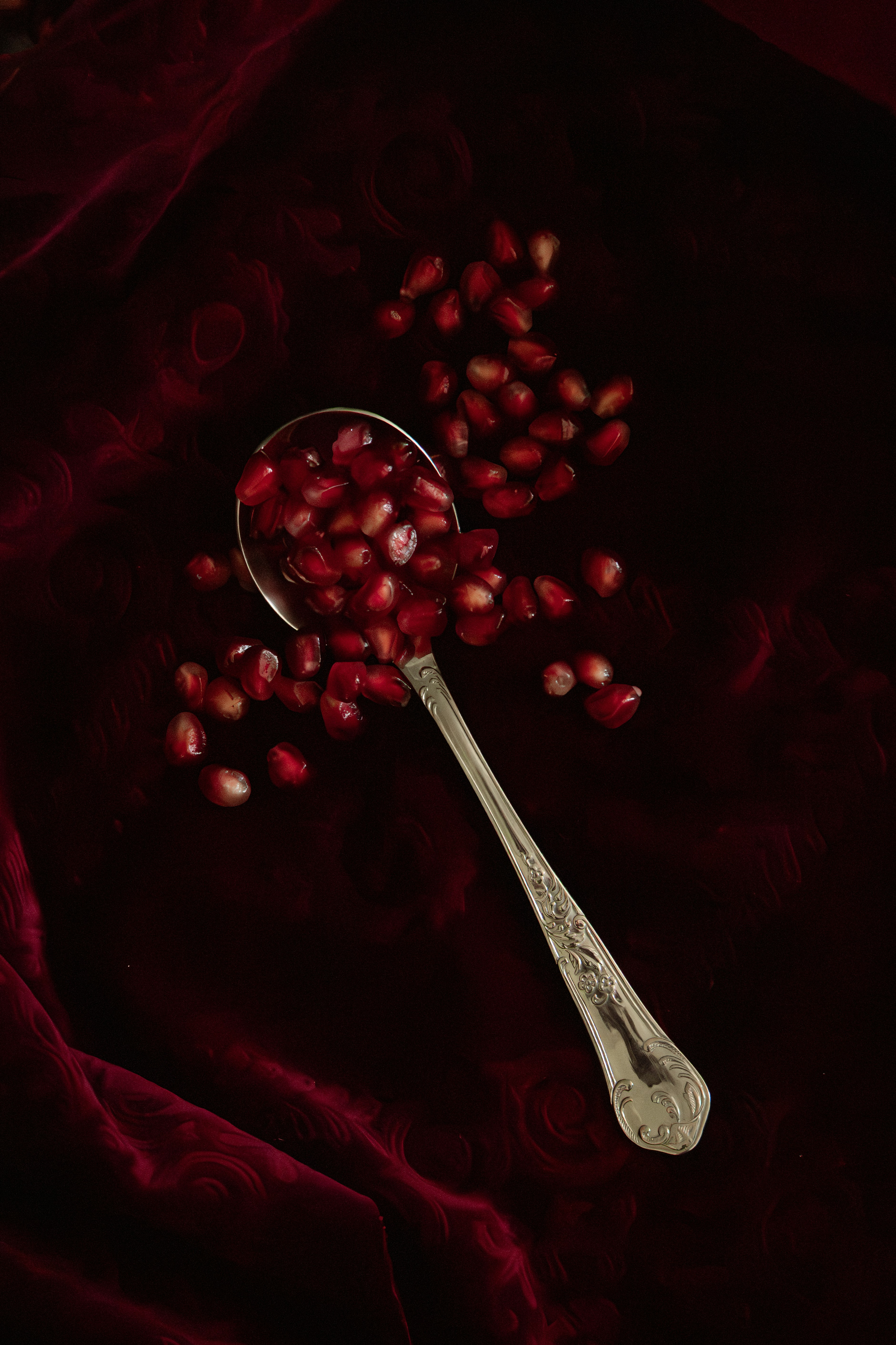 Ruby Drops on Silver: A Gentle Spill of Pomegranate Seeds