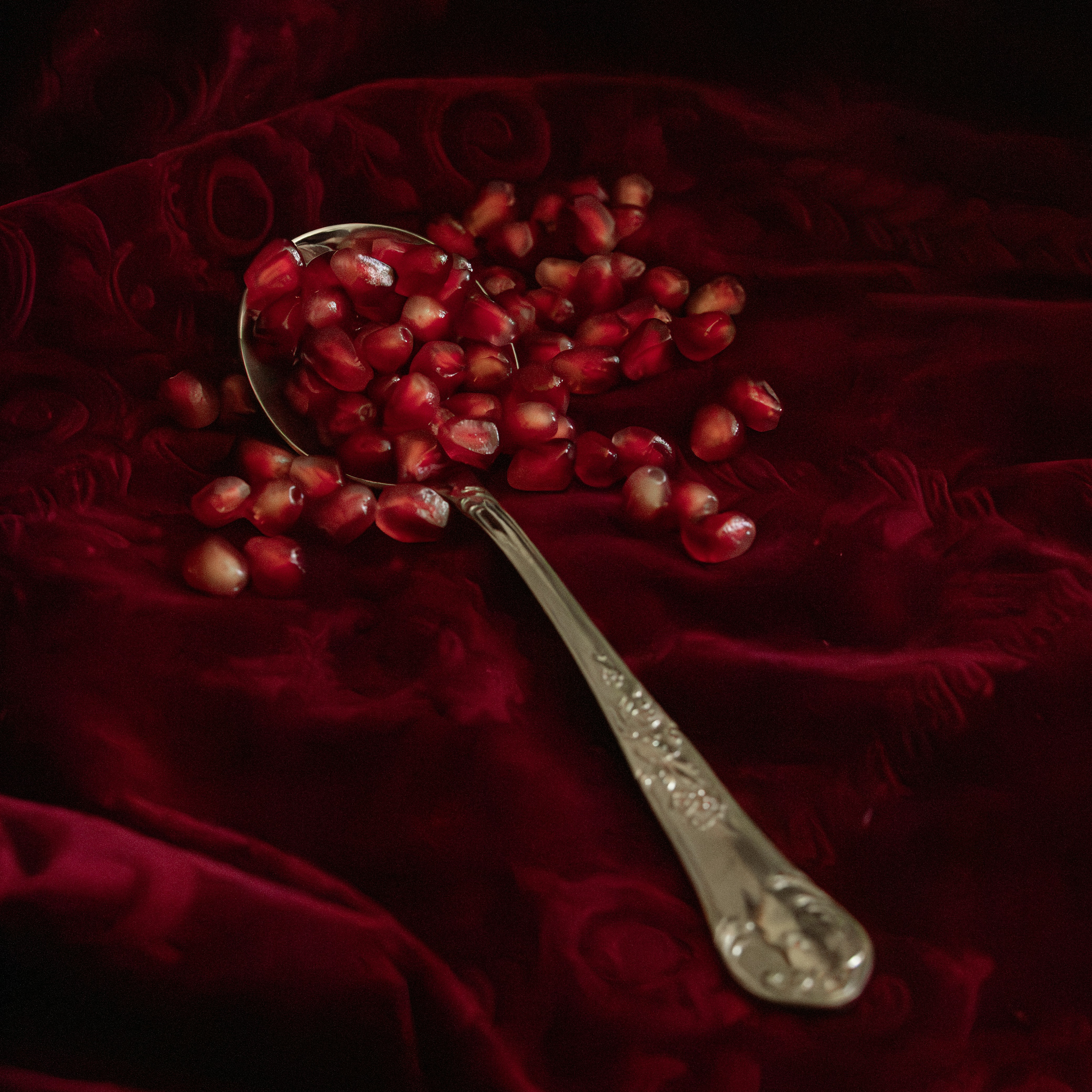 Crimson Gala: A Silver Spoon Spill of Pomegranate Seeds on Velvet Night