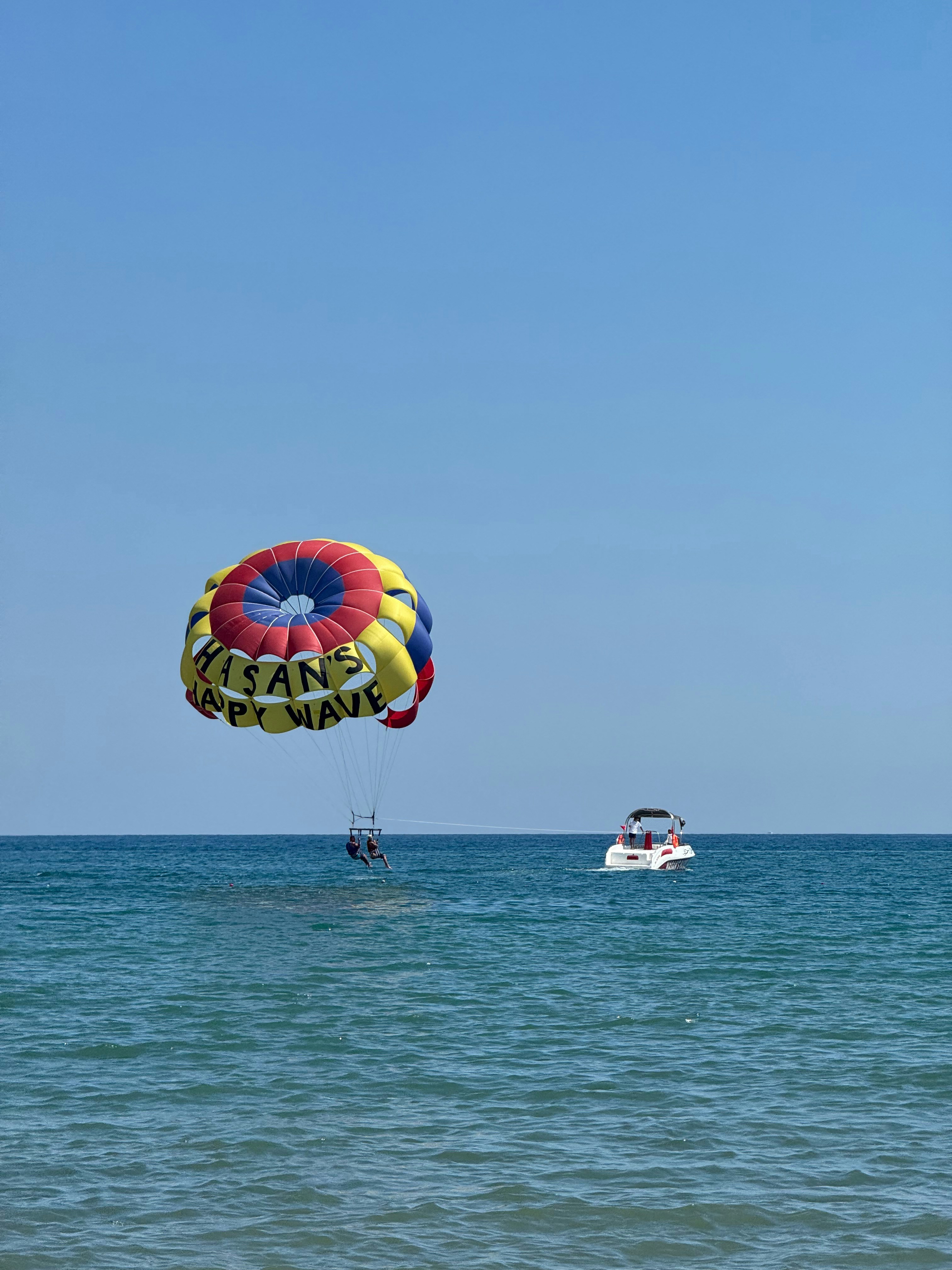 Parasail Dawn: Bright Kite Over a Calm Sea
